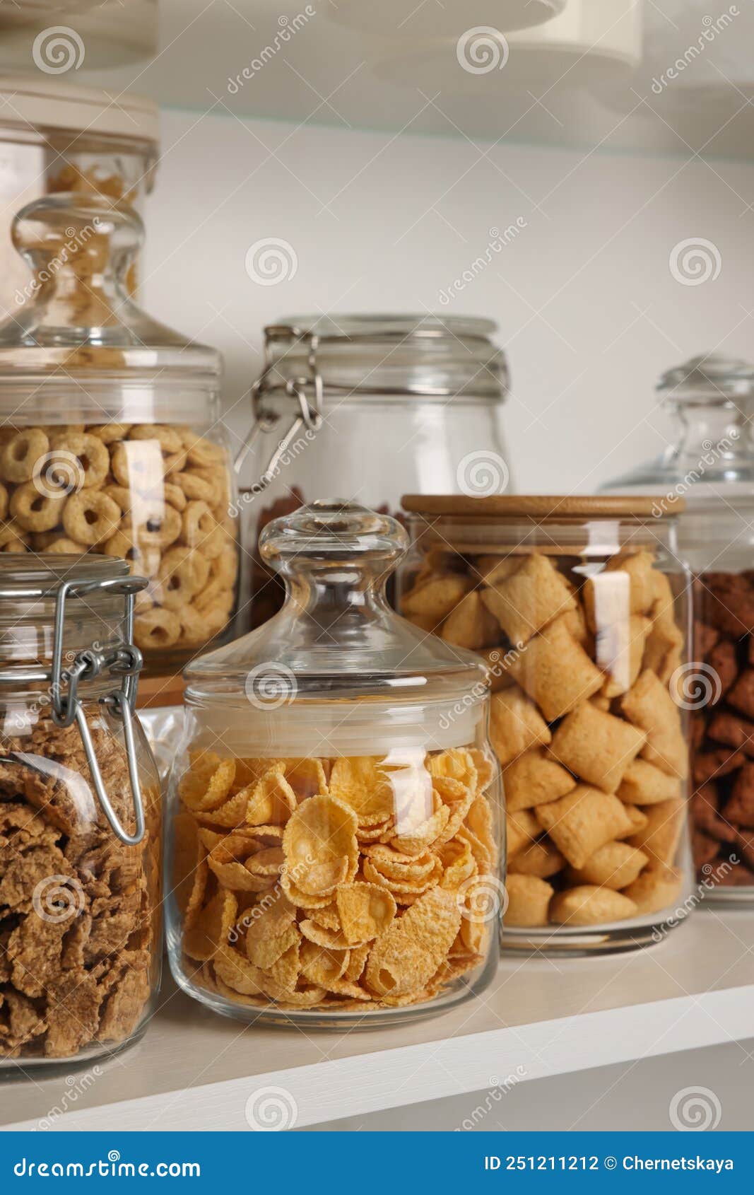 Glass Containers with Different Breakfast Cereals on Shelf Stock Photo ...