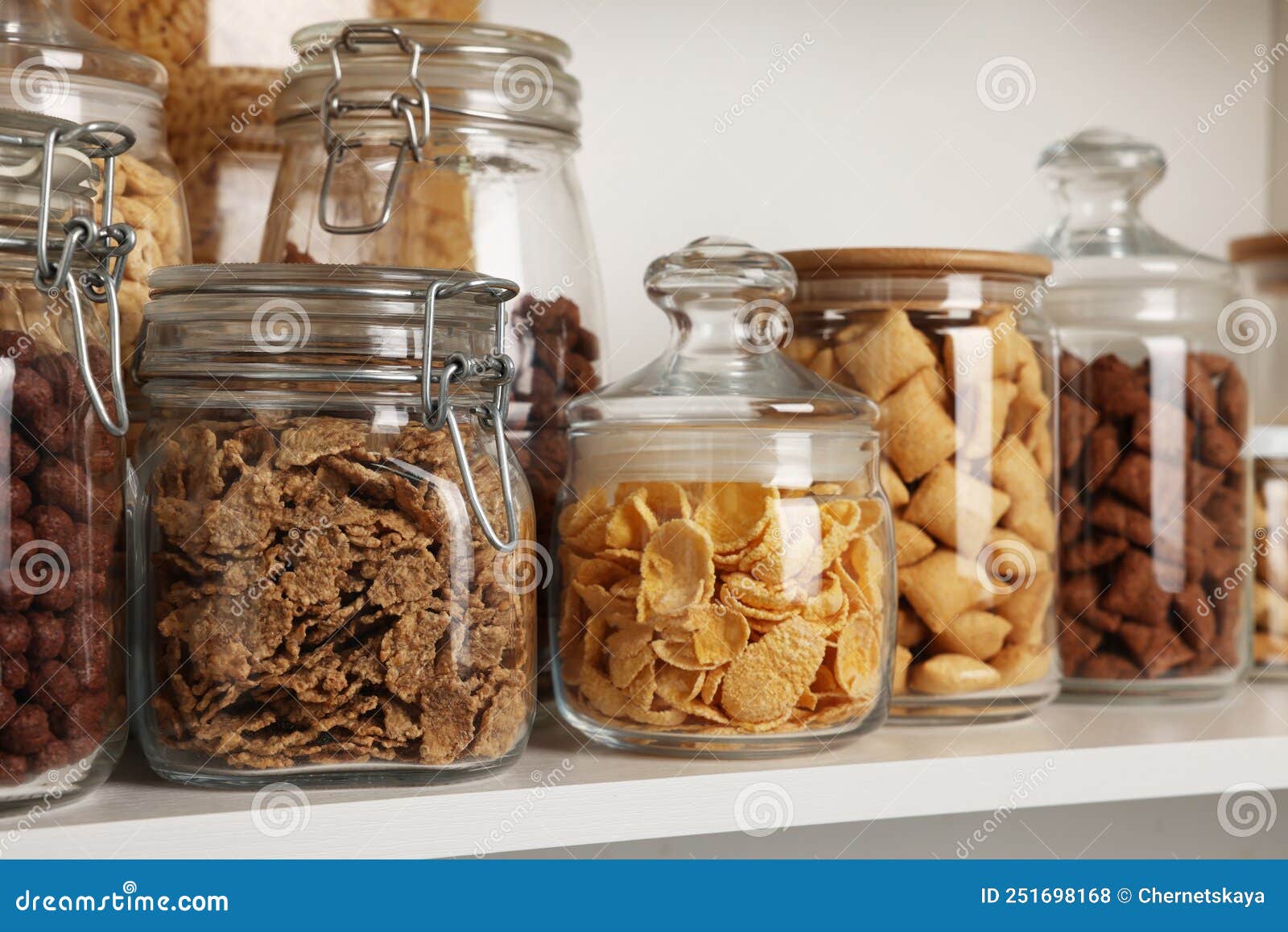 Glass Containers with Different Breakfast Cereals on Shelf Stock Photo ...