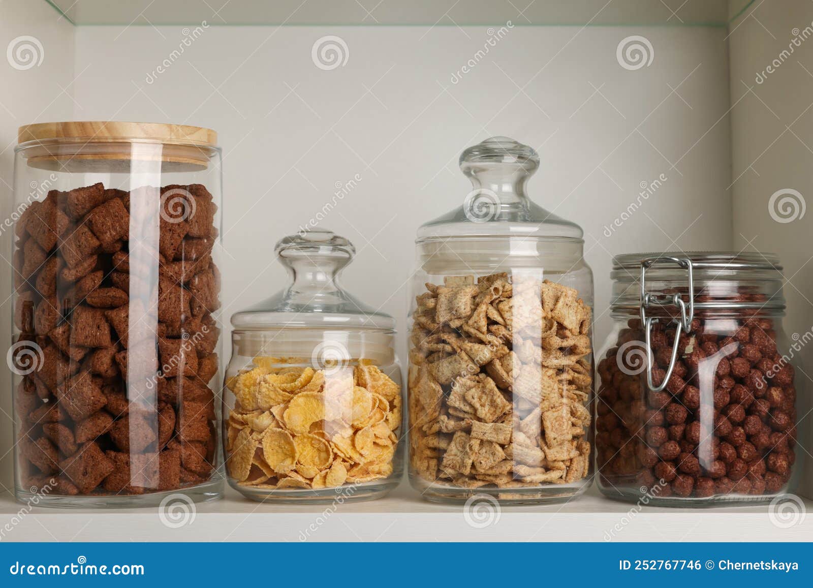 Glass Containers with Different Breakfast Cereals on Shelf Stock Photo ...