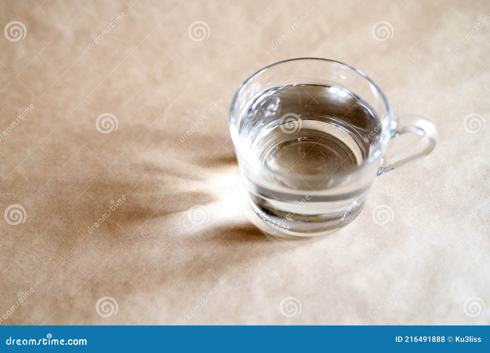 A Glass Cup of Clear Water on Beige Craft Paper Background and ...