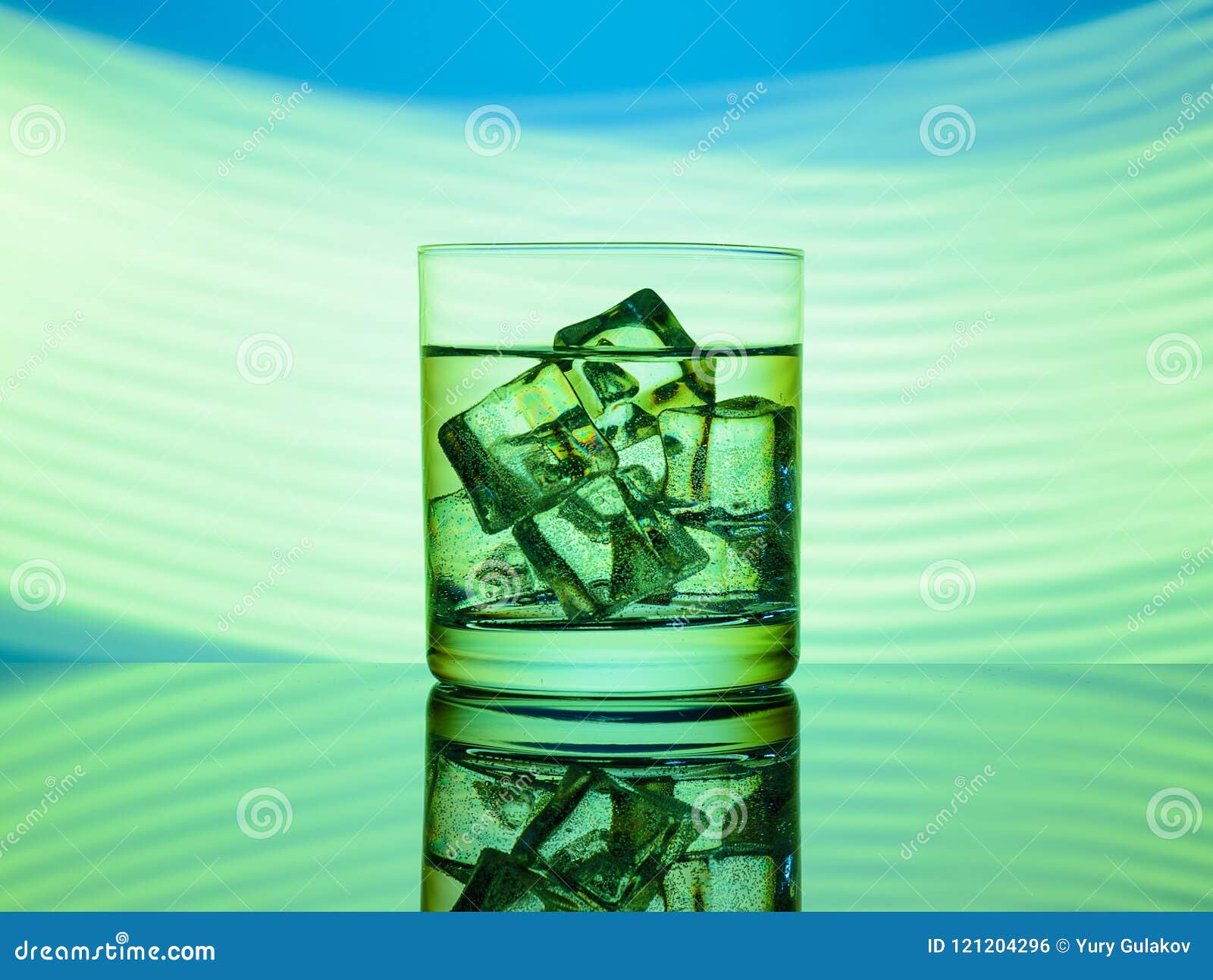 A Glass with a Drink and Ice Cubes on a Blue Background Stock Photo ...