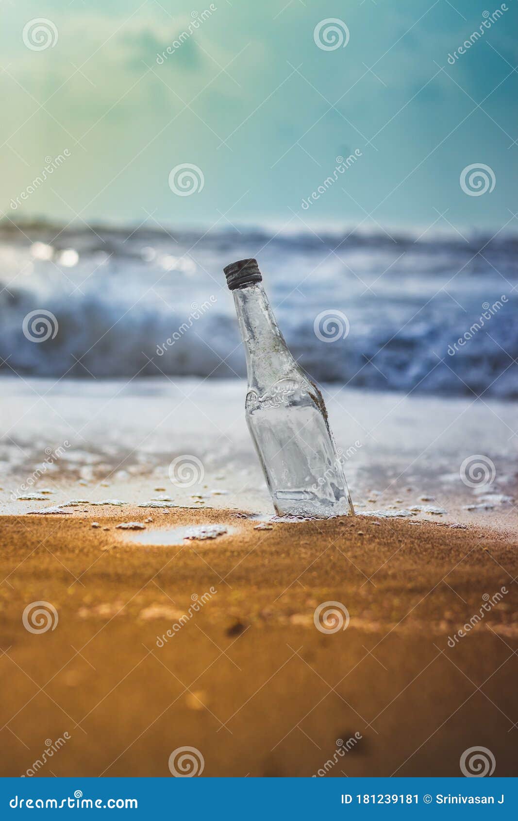 Glass Empty Bottle in Coast Sand and Sky with Clouds. Bottle in the ...
