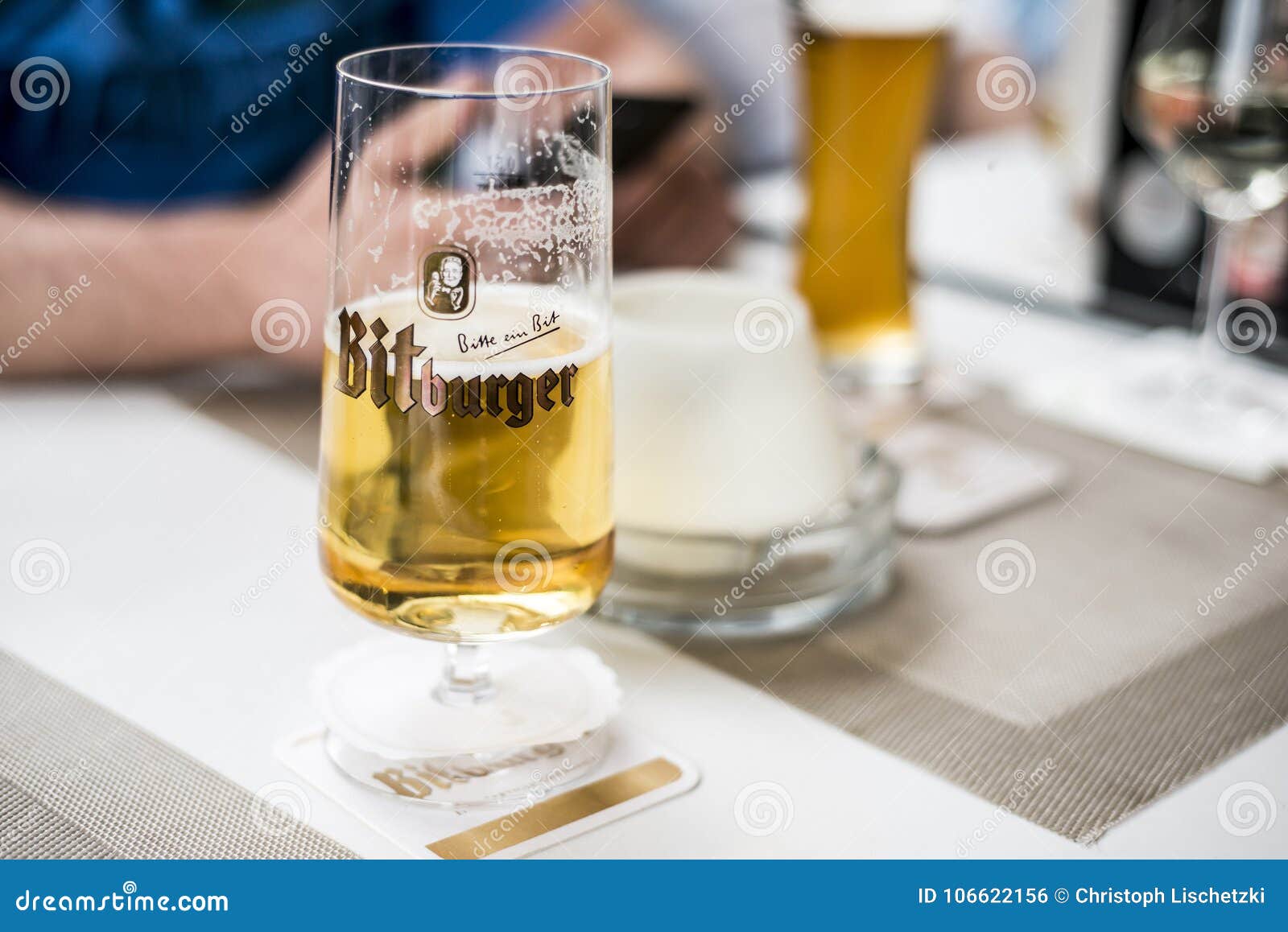 A Glass of German Beer on a Table with Bitburger Company Logo Editorial ...