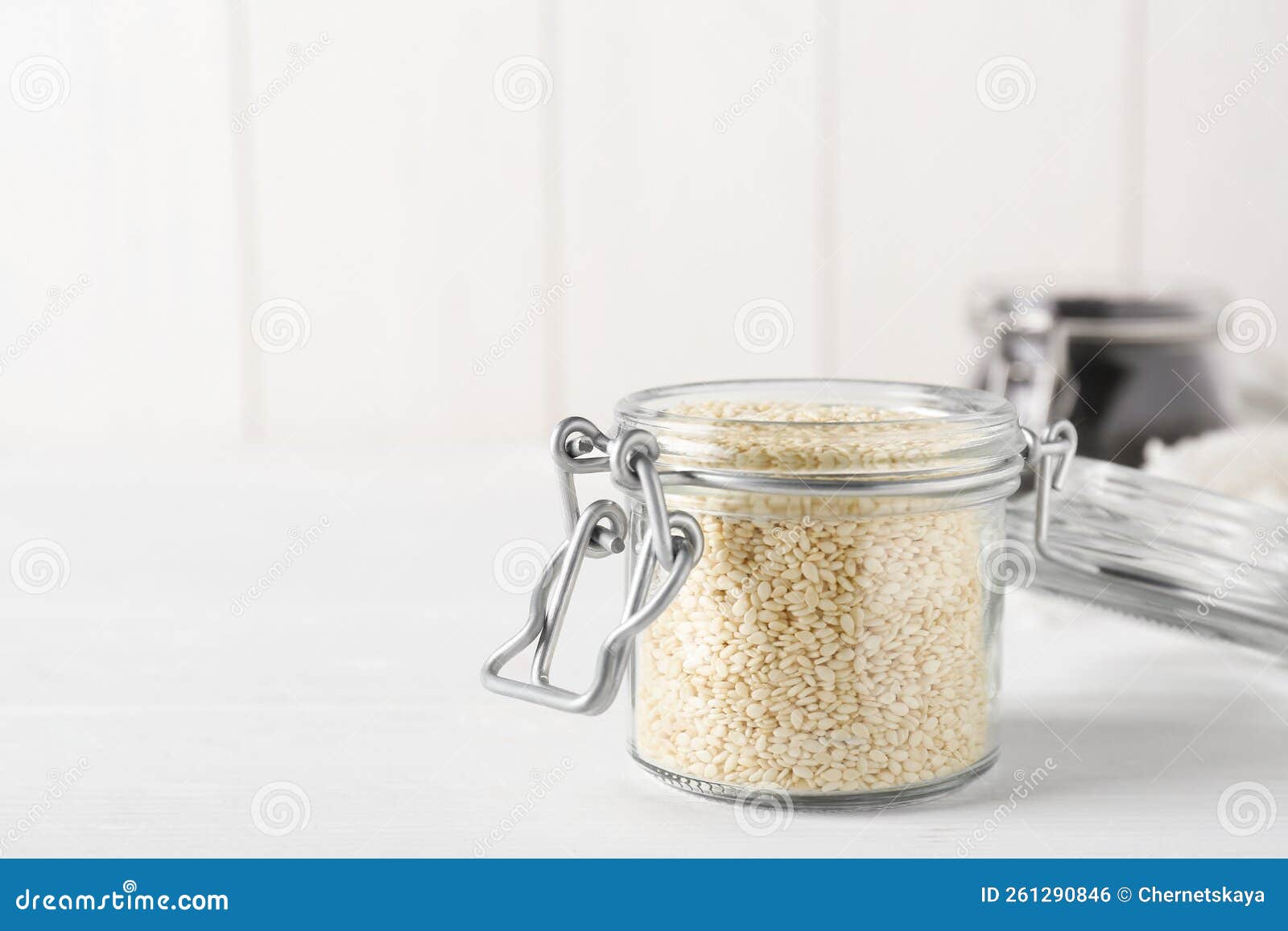 Glass Jar with Sesame Seeds on White Wooden Table, Space for Text Stock ...