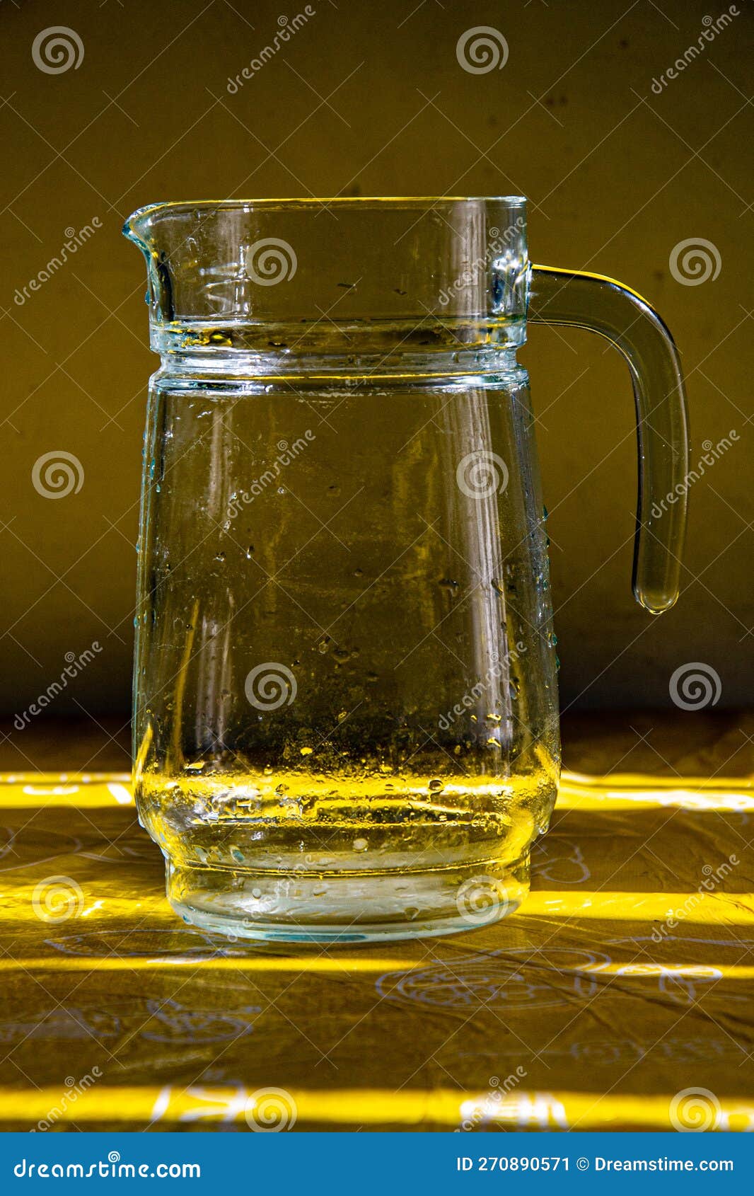 A glass jug on the table stock image. Image of yellow - 270890571