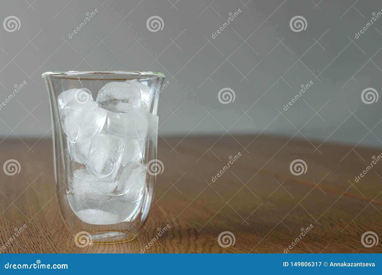 Glass with Melting Ice Pieces on the Wooden Table. Ice is Partially ...