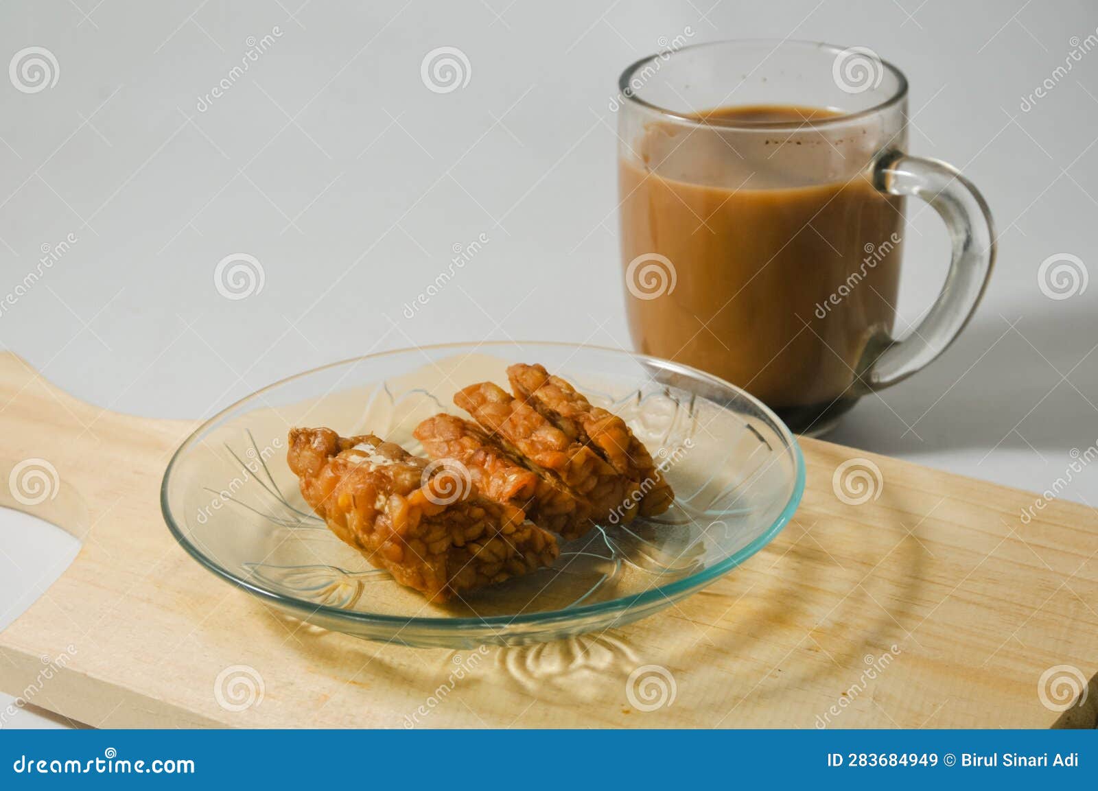 A Glass of Milk Coffee and Two Pieces of Fried Tempeh on a Small Plate ...
