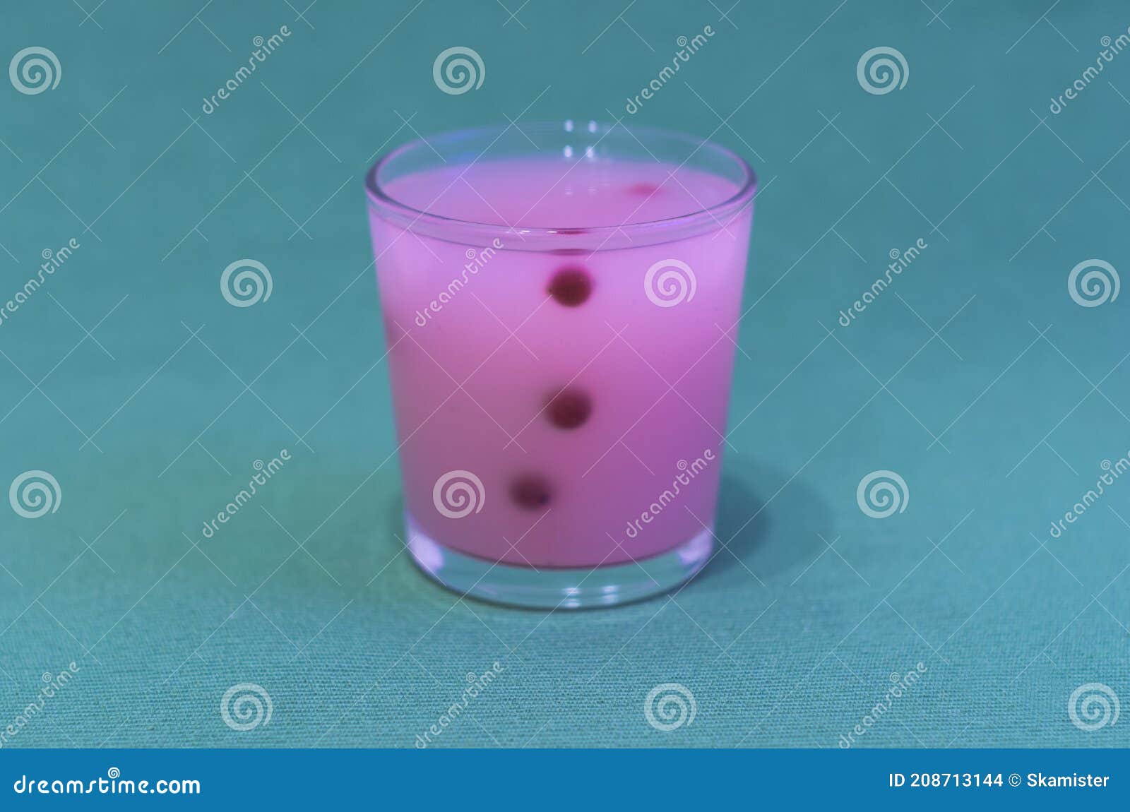A Glass with a Pink Cloudy Drink on a Blue Background Stock Photo ...