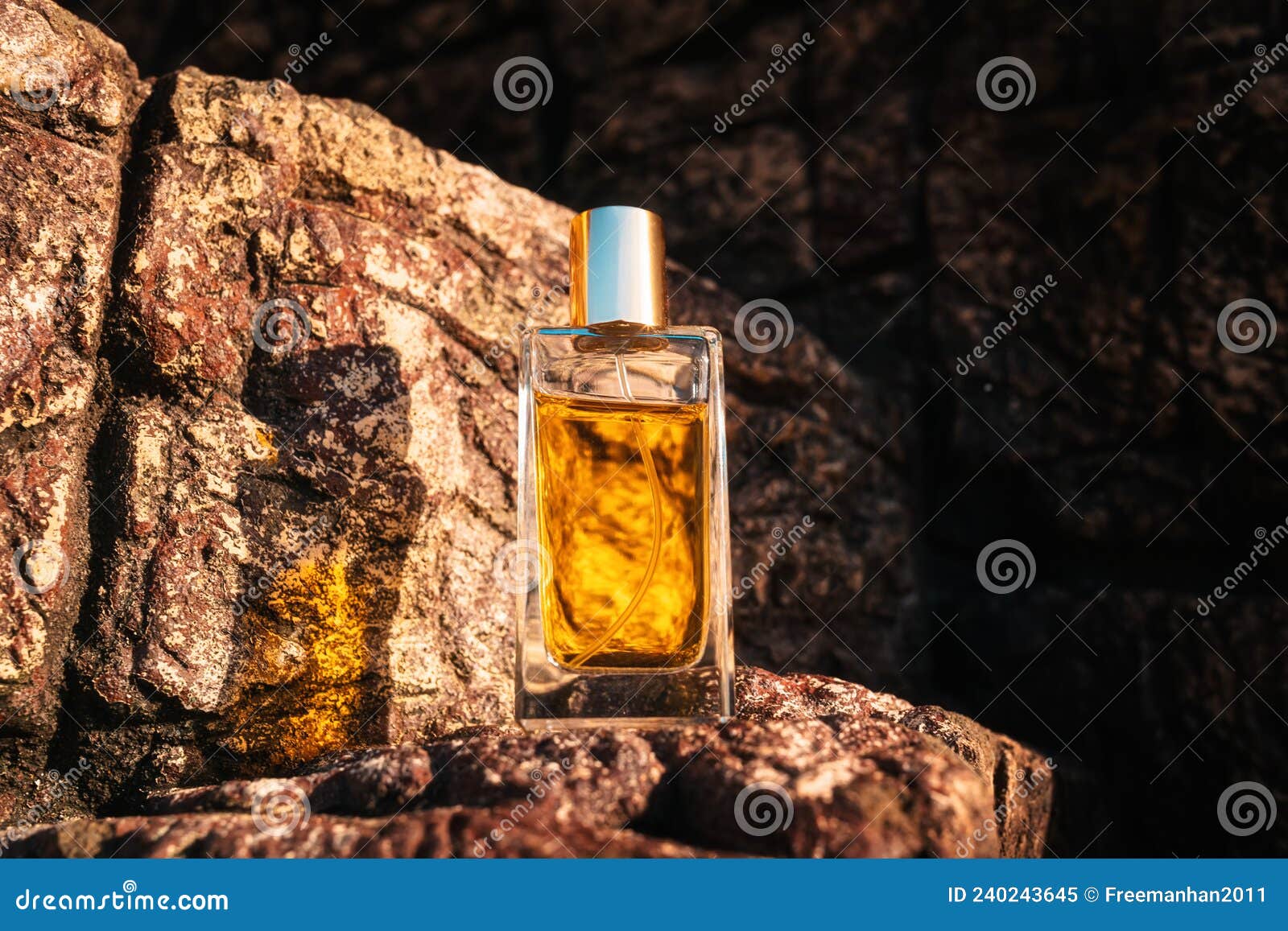 A Glass Rectangular Bottle of Golden Perfume Standing on a Stone. Copy ...