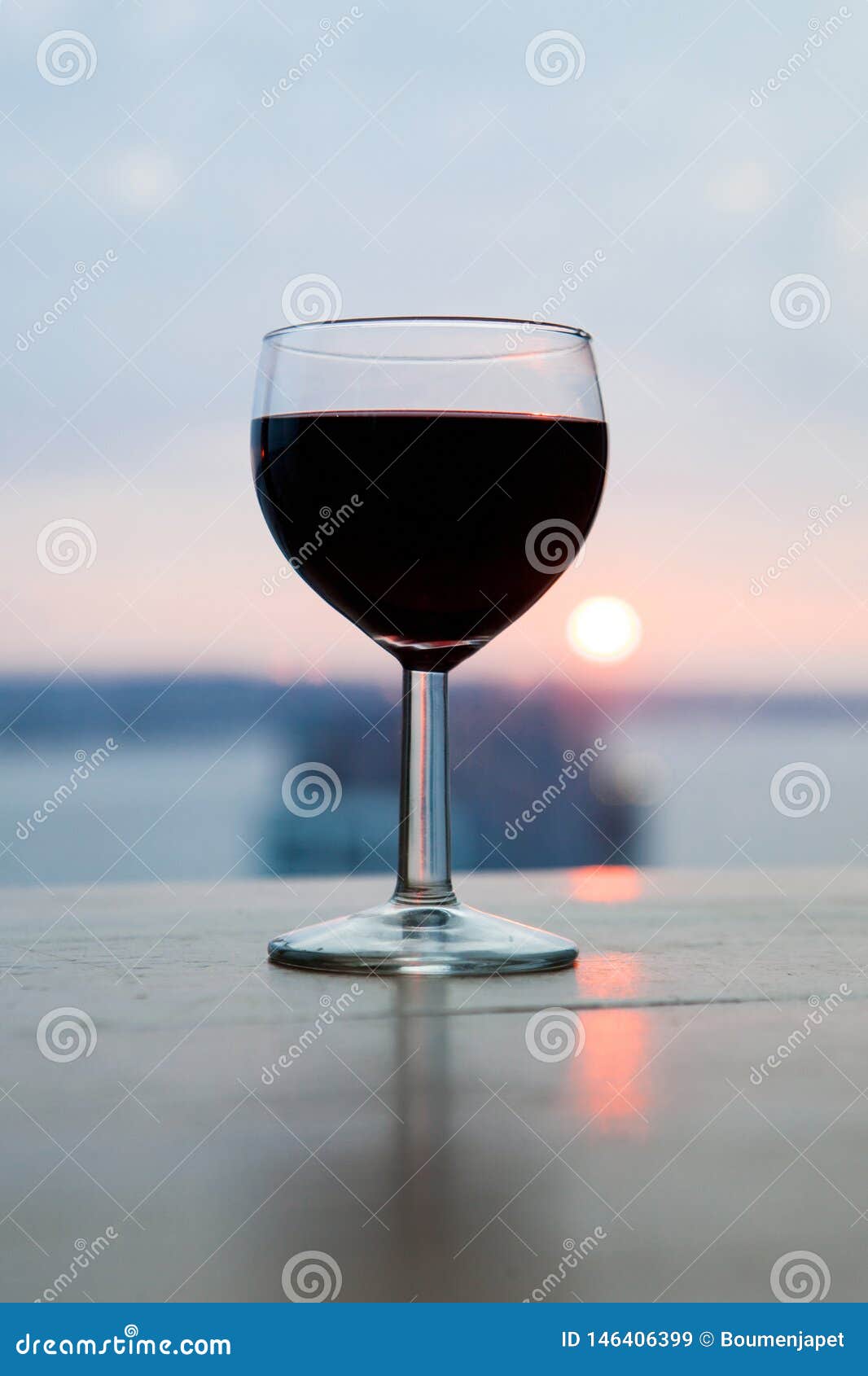 A Glass of Red Wine in Front of the Beautiful Soft Sunset. Stock Image ...
