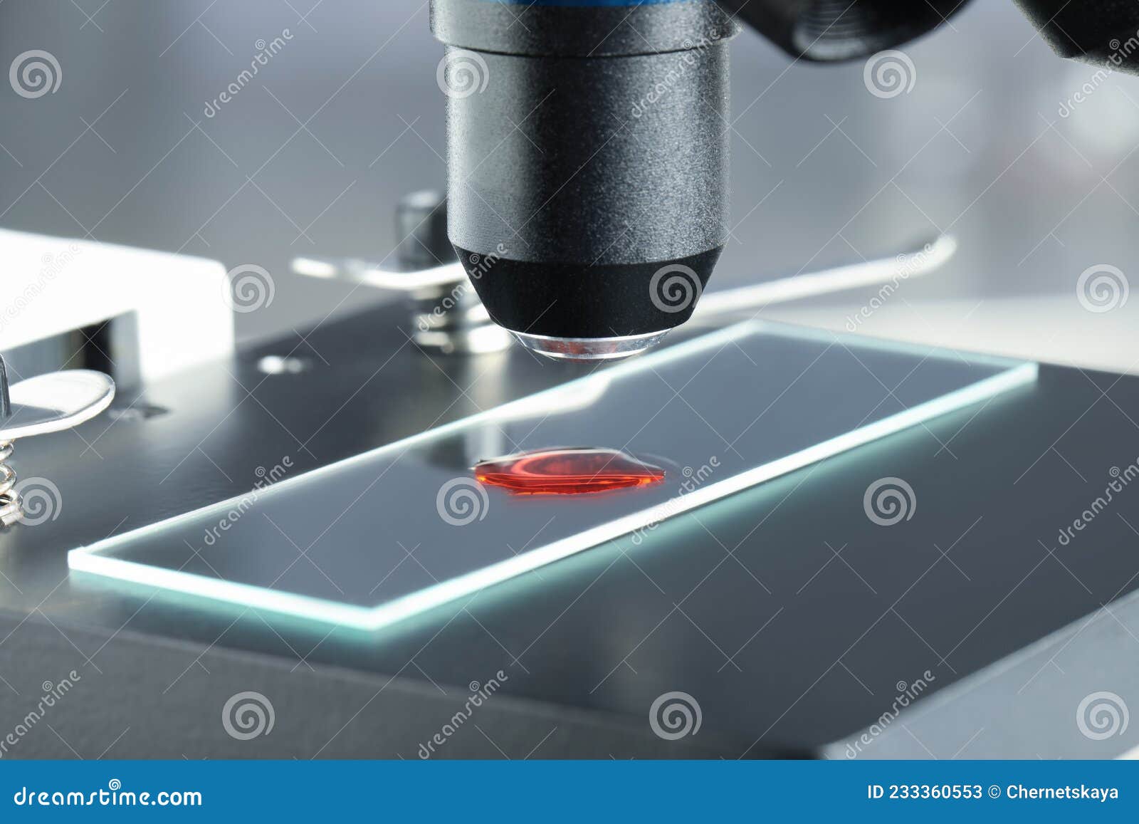 Glass Slide with Sample of Red Liquid Under Microscope in Laboratory ...