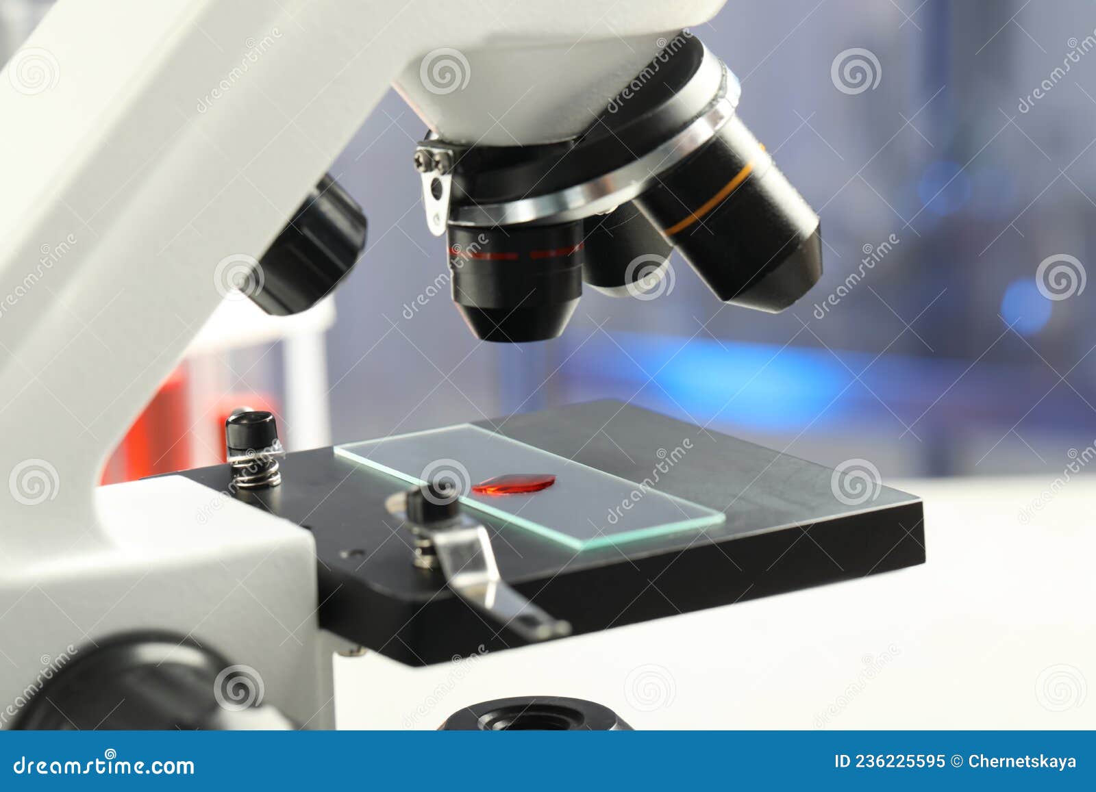 Glass Slide with Sample of Red Liquid Under Microscope in Laboratory ...
