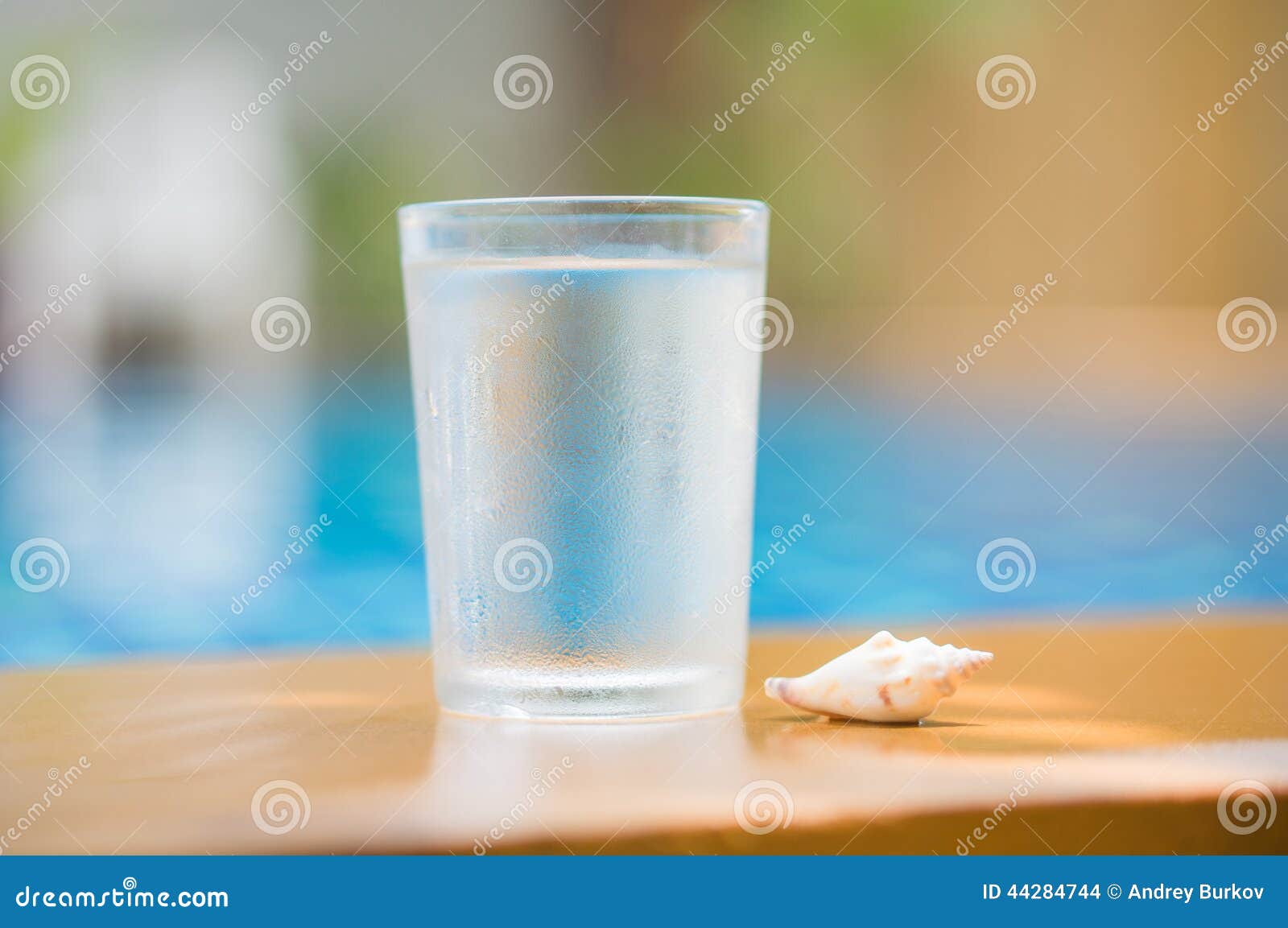 Glass of Water with Drops and Small Shell on Pool Side in Tropic Stock ...