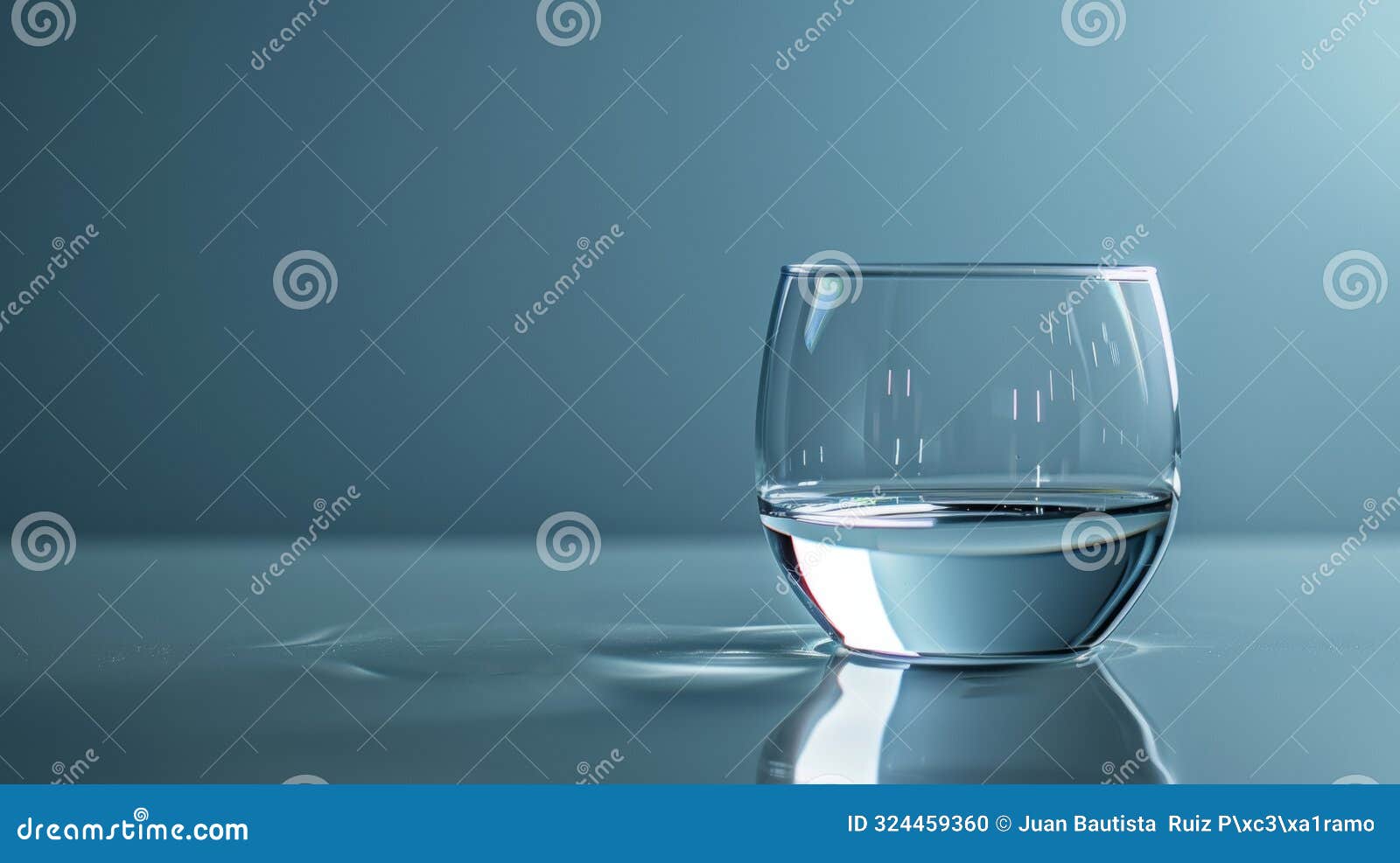 Glass of Water on Reflective Surface with Blue Background Stock Photo ...