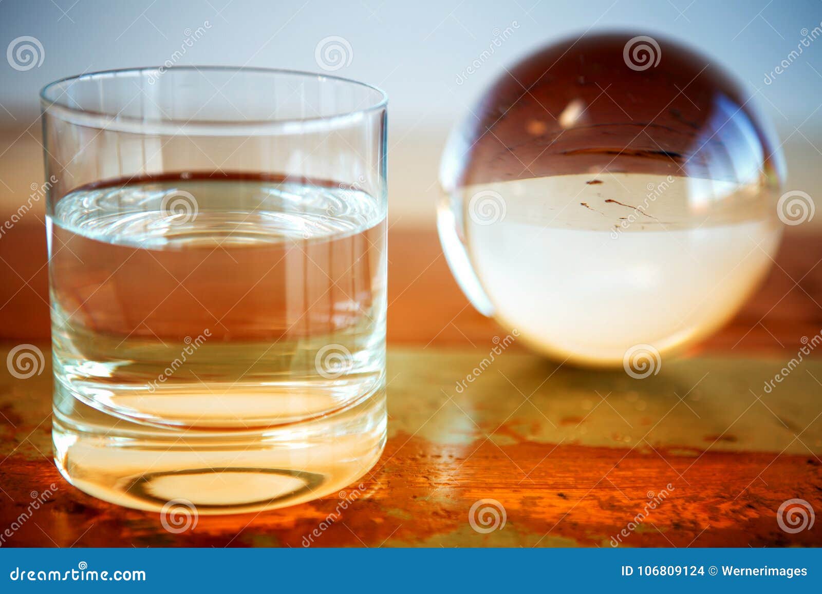 Glass of Water and Glass Sphere on Table Stock Photo - Image of ...