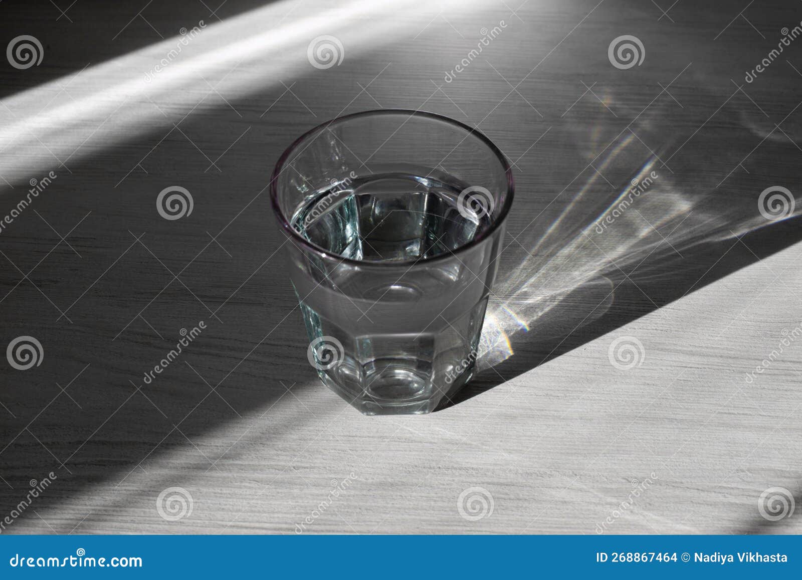 A Glass of Water on the Table, Illuminated by the Rays of the Sun ...