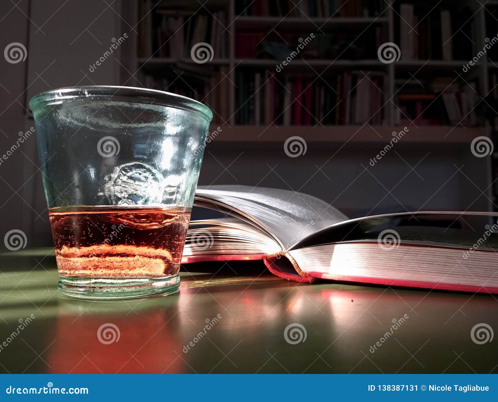 Glass Of Wine On A Table With A Open Book With A Bookshelf On The Background Stock Image Image