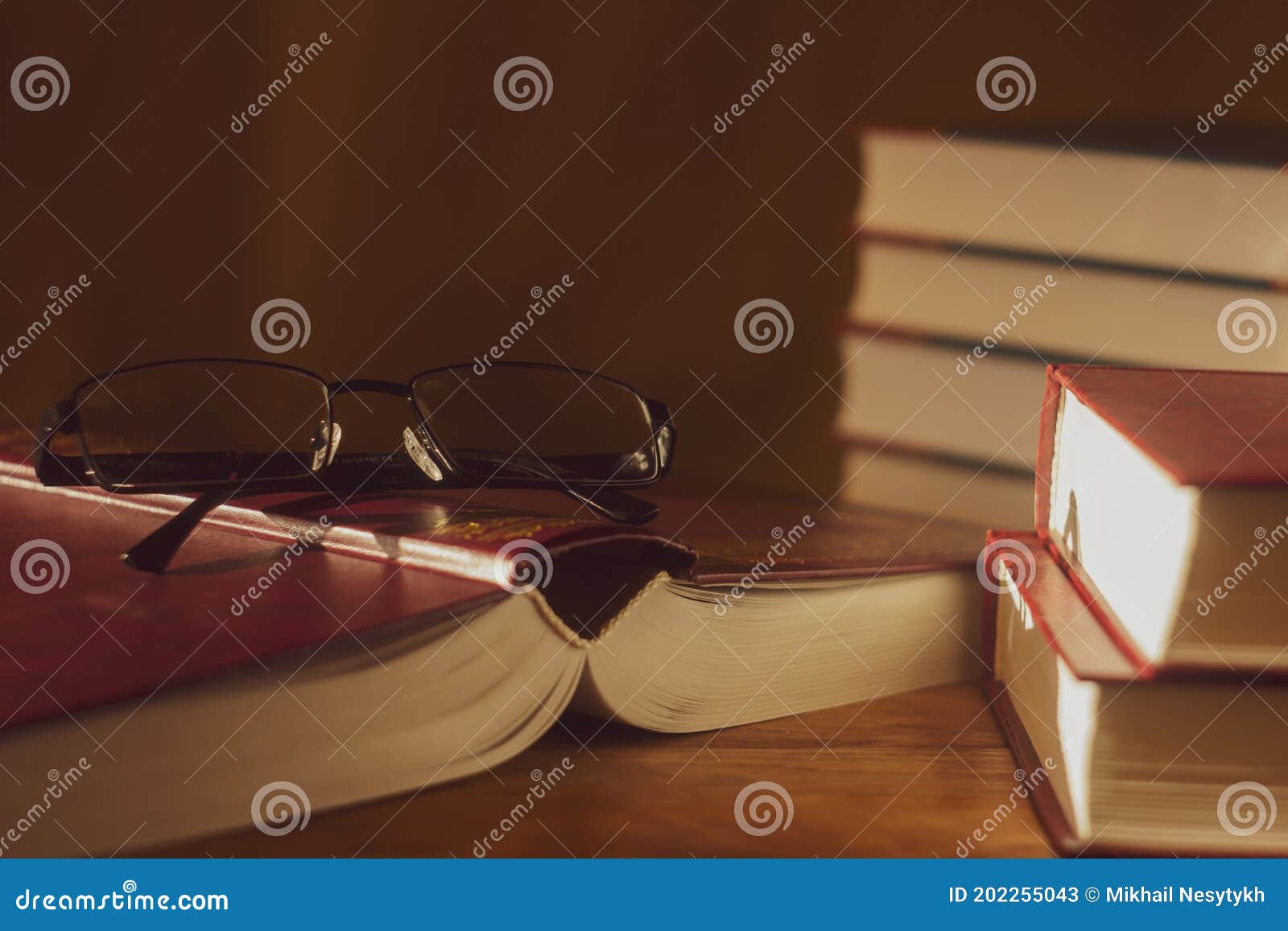 Glasses on an Overturned Open Book Against the Background of Stacks of ...