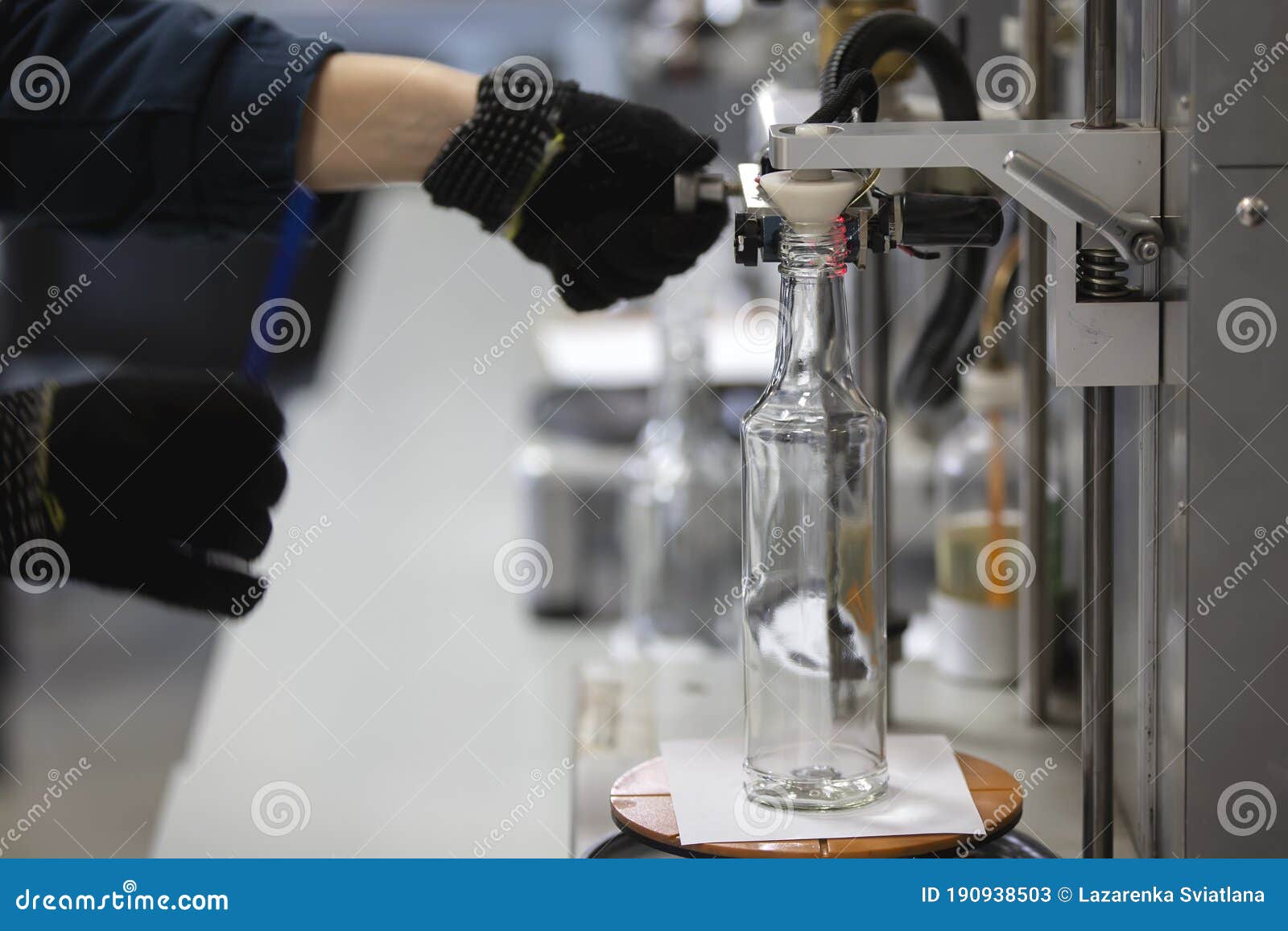 Glassworks. Hands Hold a Glass Bottle Over the Device Stock Image ...