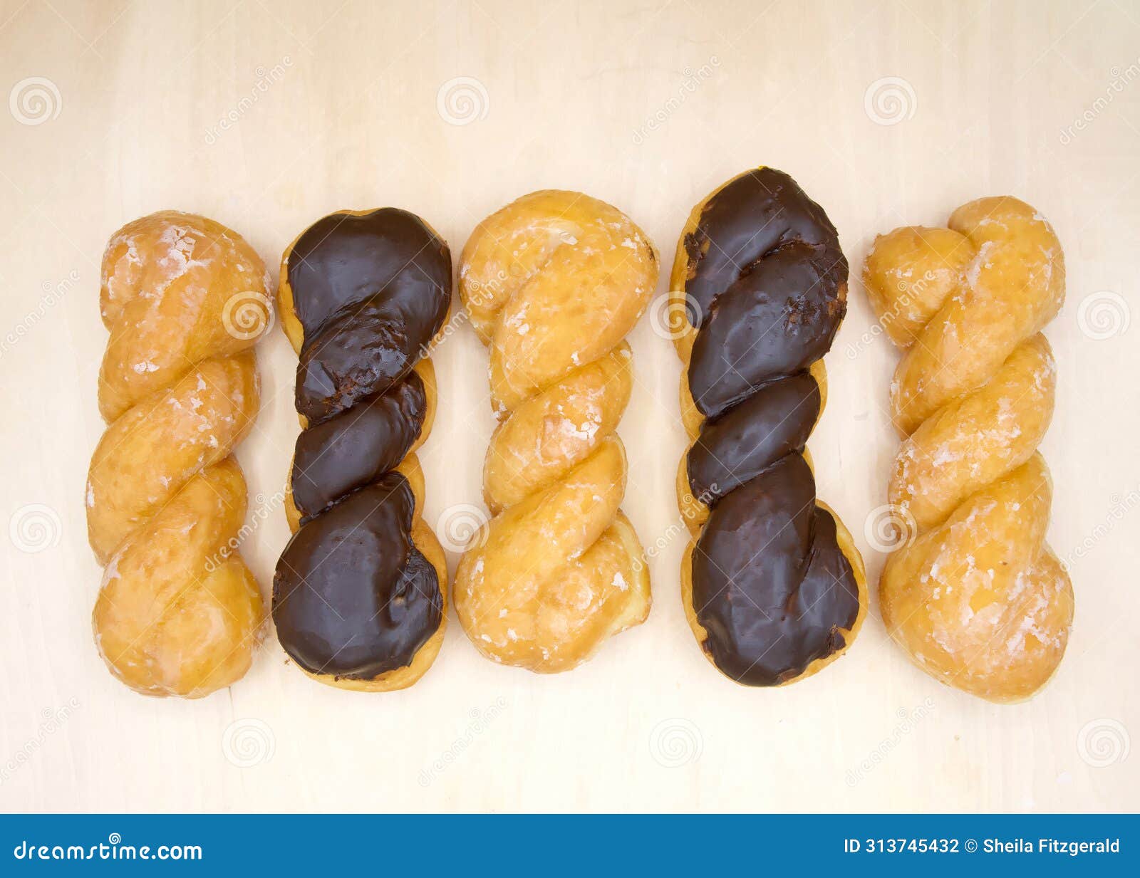 Glazed and Chocolate Covered Twist Donuts on a Light Wood Surface ...