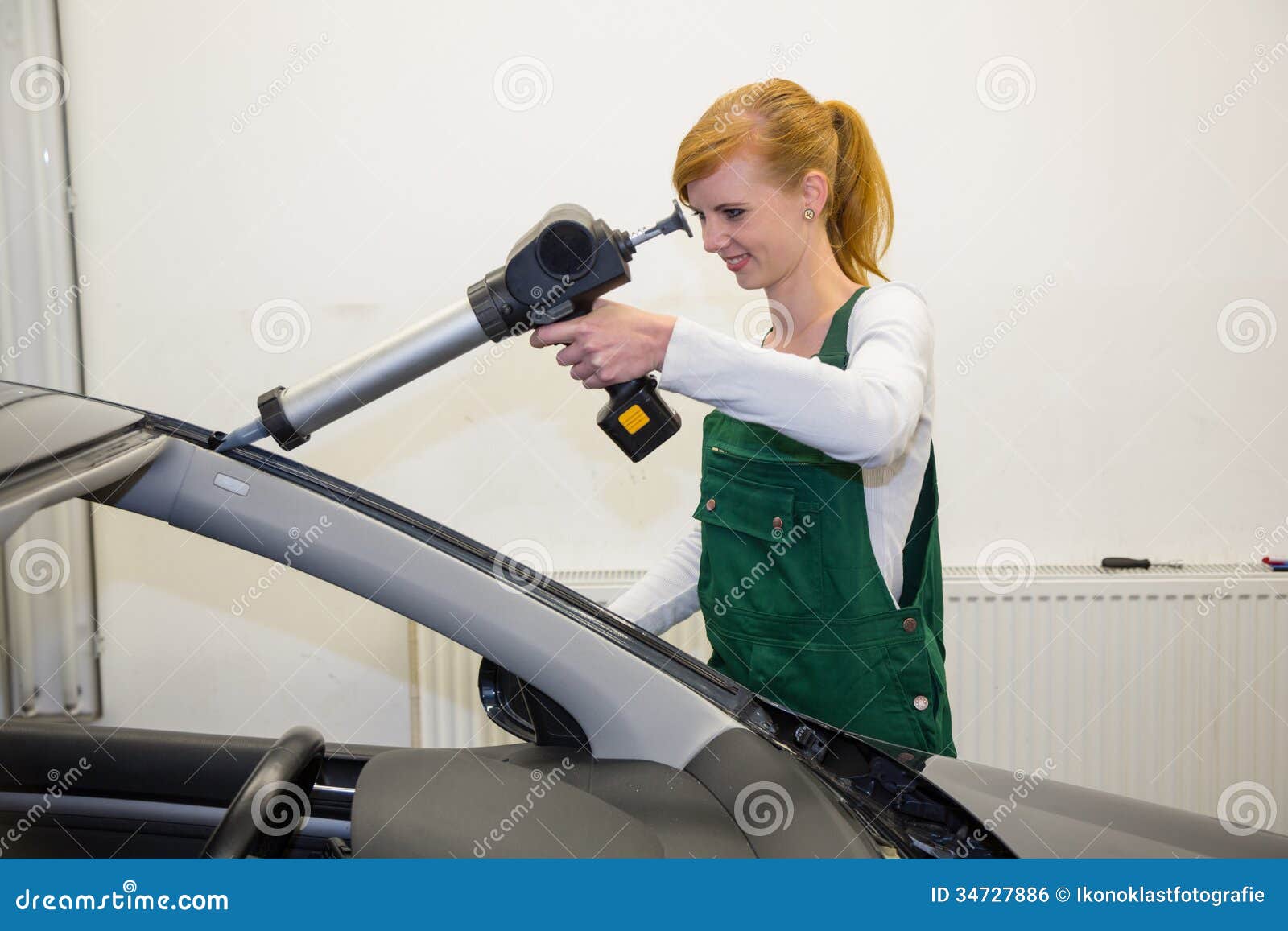 Glazier with Application Gun in Garage Replacing Windshield or ...