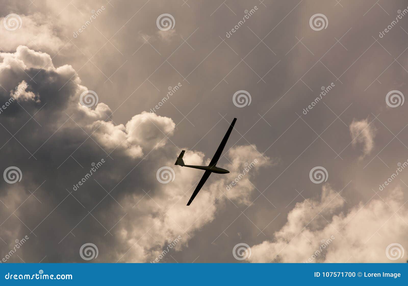 A Glider Flying in Sky with Big Threatening Clouds. the Glider is a ...