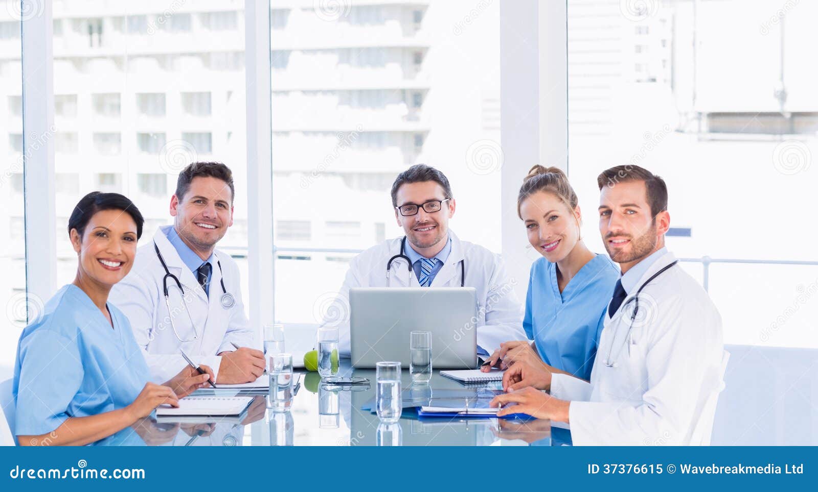 Glimlachend Medisch Team Rond Bureau in Bureau Stock Afbeelding - Image ...