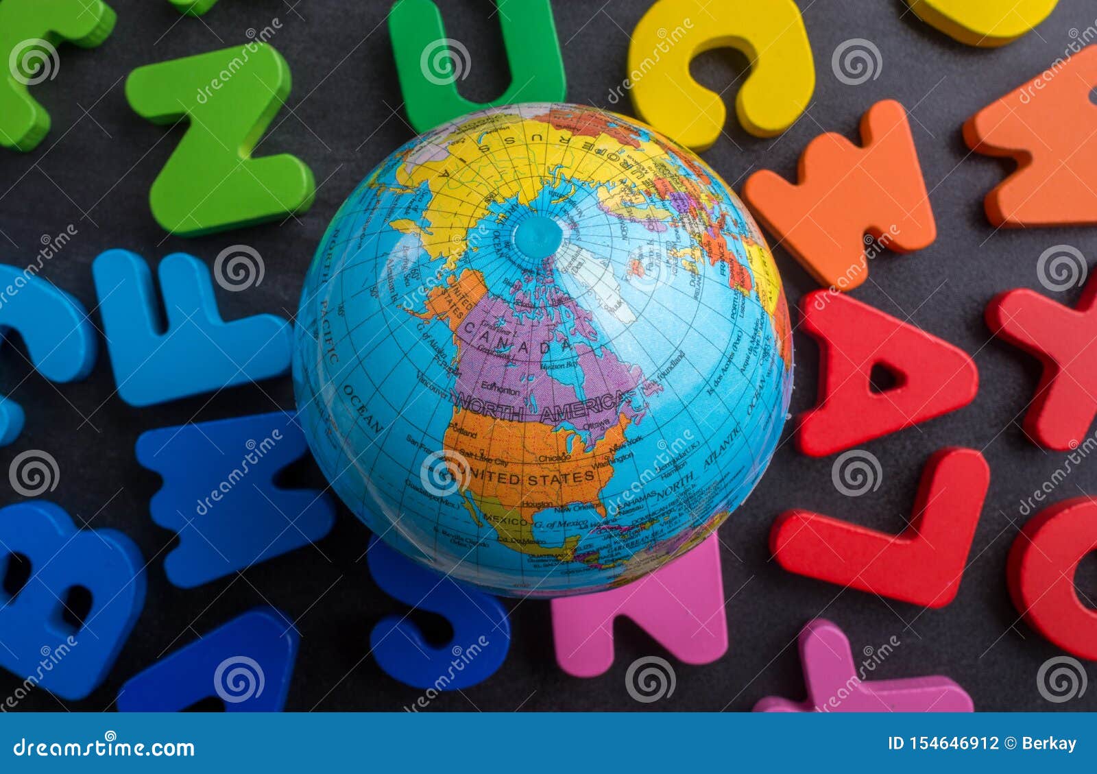 Globe Model on Colorful Letters on a Black Background Stock Photo ...