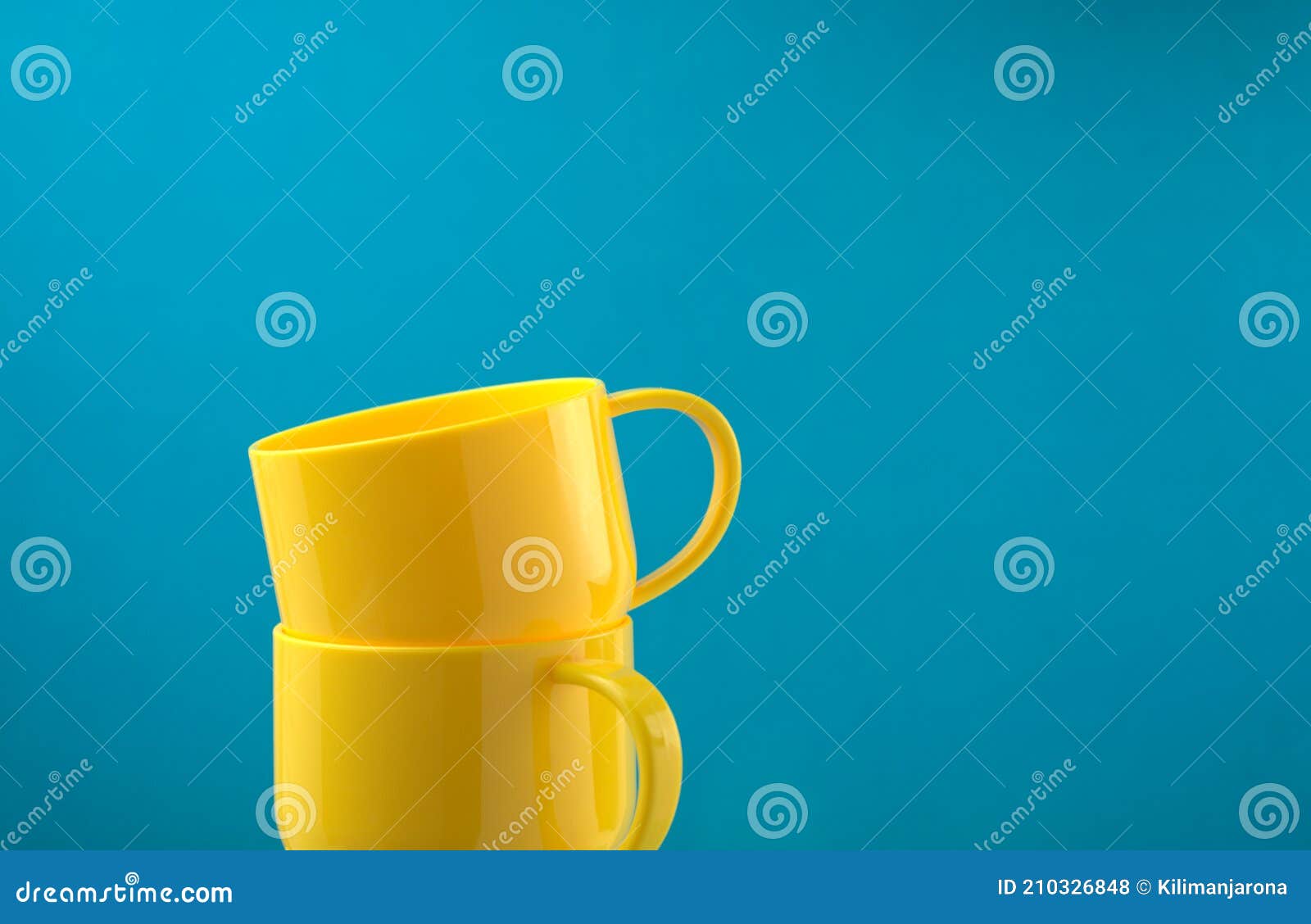 Glossy Yellow Colored Cups Stacking on Blue Background. Off-center ...