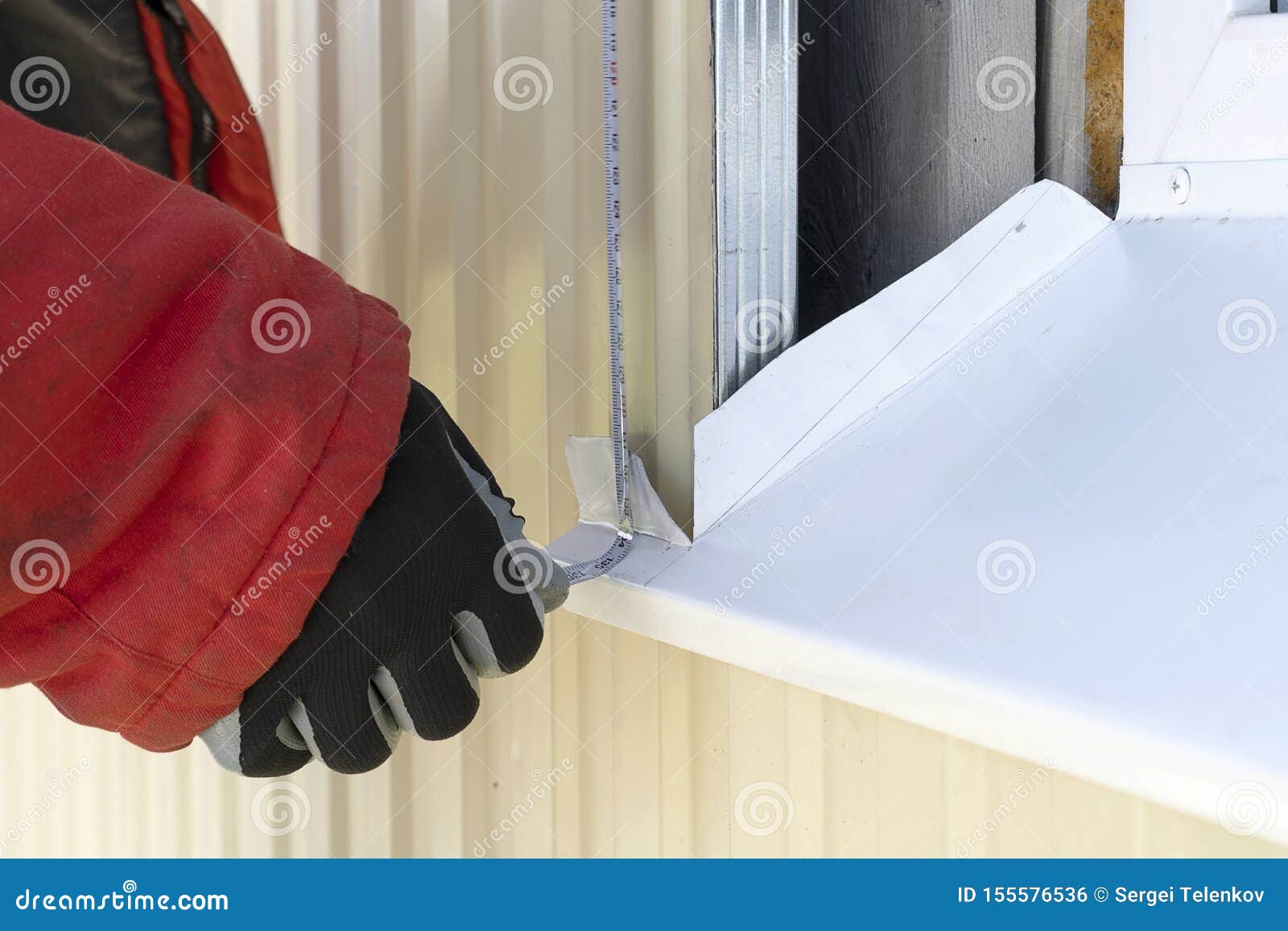 A Gloved Craftsman Measures the Window Frame with a Tape Measure ...