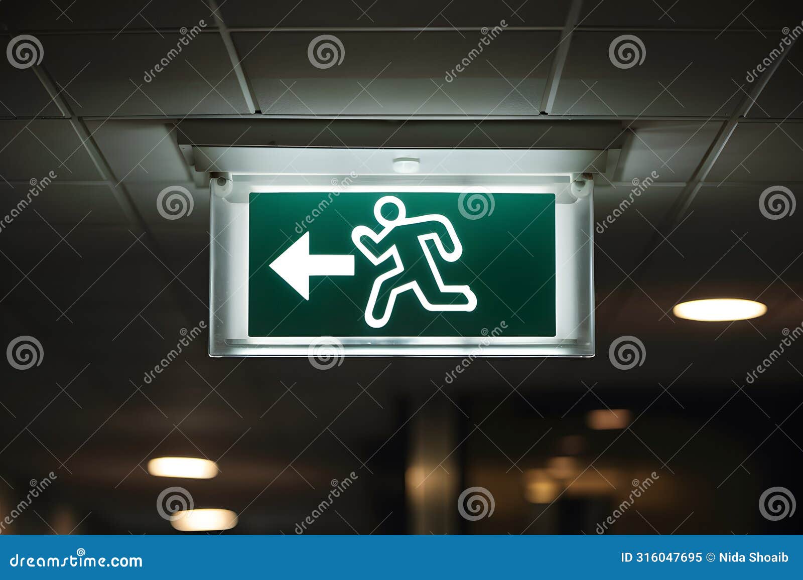 Glowing Emergency Exit Sign with Running Figure and Arrow in Dim ...
