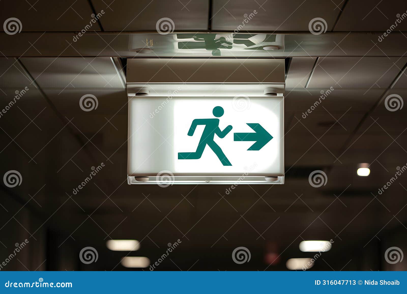 Glowing Emergency Exit Sign with Running Figure and Arrow in Dim ...