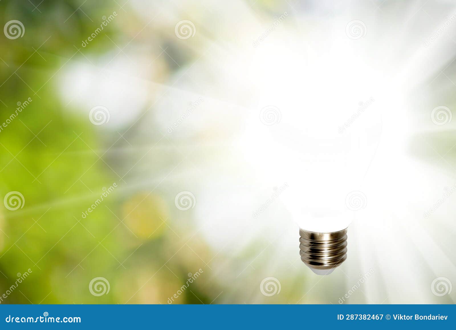 Glowing Light Bulb on a Green Blurred Background. the Concept of the ...