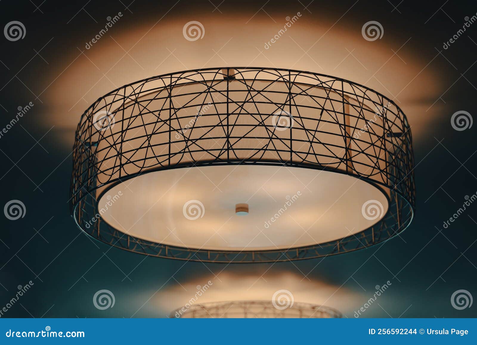 A Glowing and Lit Drum Light with Black Metal Accents on a Warm Ceiling ...
