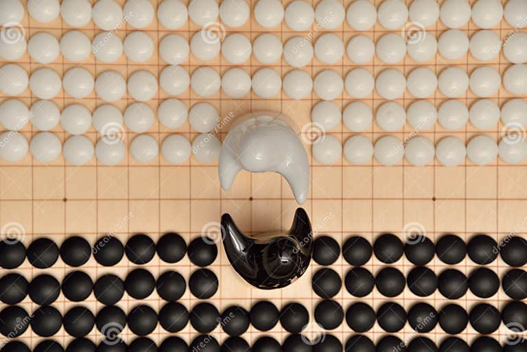 Go Game Pieces and Two Black and White Figures Stock Photo - Image of ...