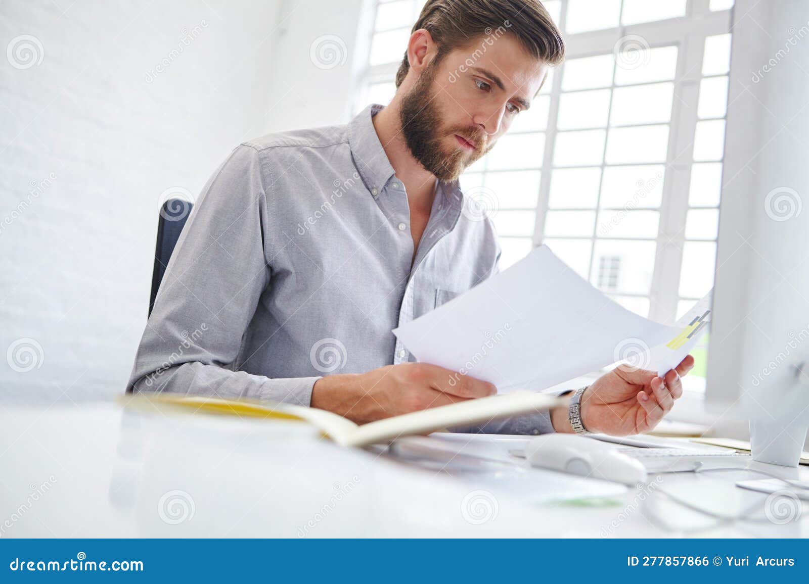 Going Over the Paperwork. a Young Designer Holding Paperwork while ...