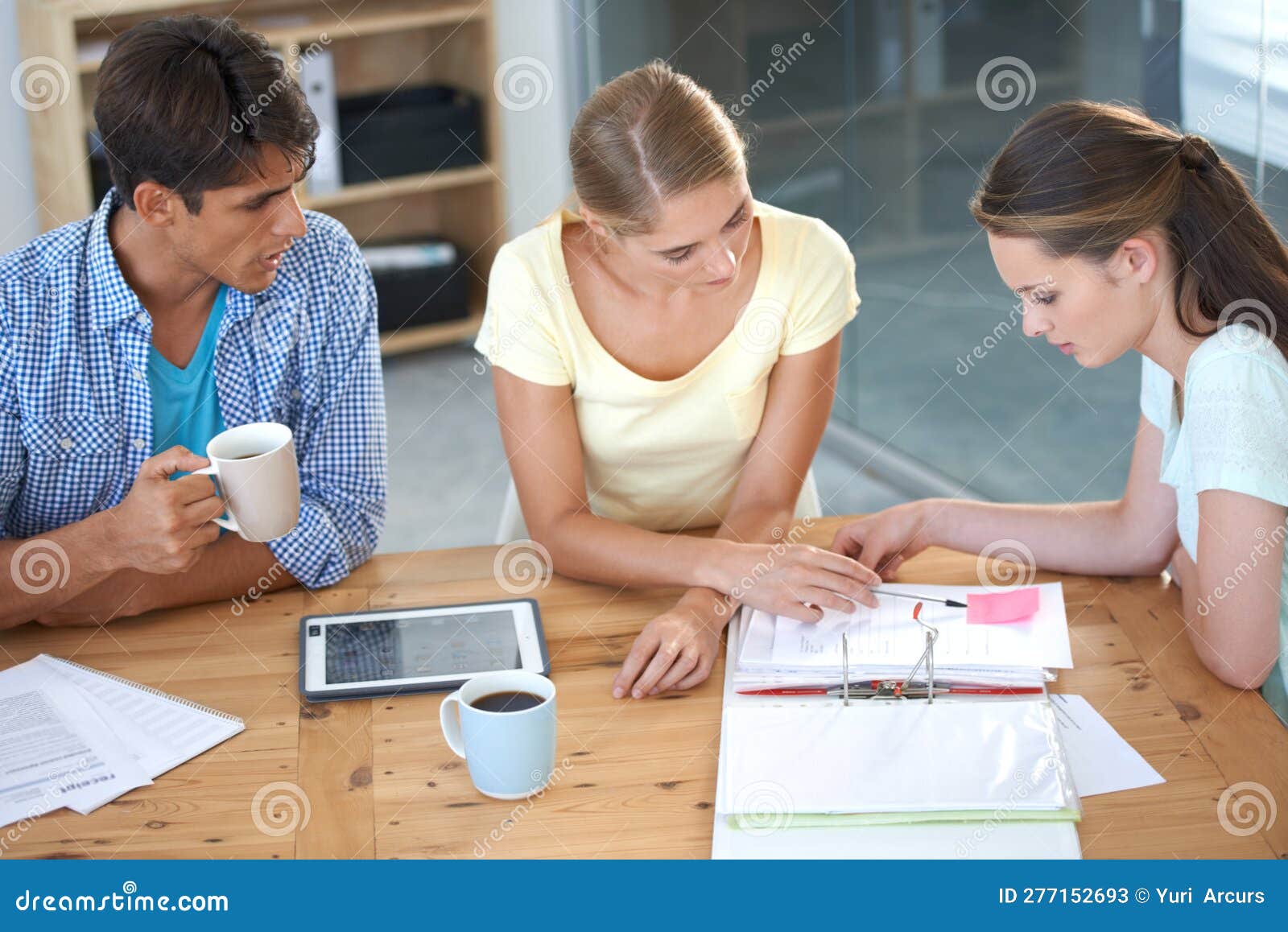 Going Over the Schedule. Three Colleagues Working in an Office. Stock ...