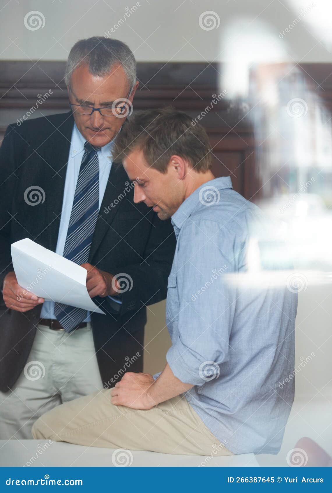 Going Over Sensitive Documents. through-the-window Shot of a Young Man ...