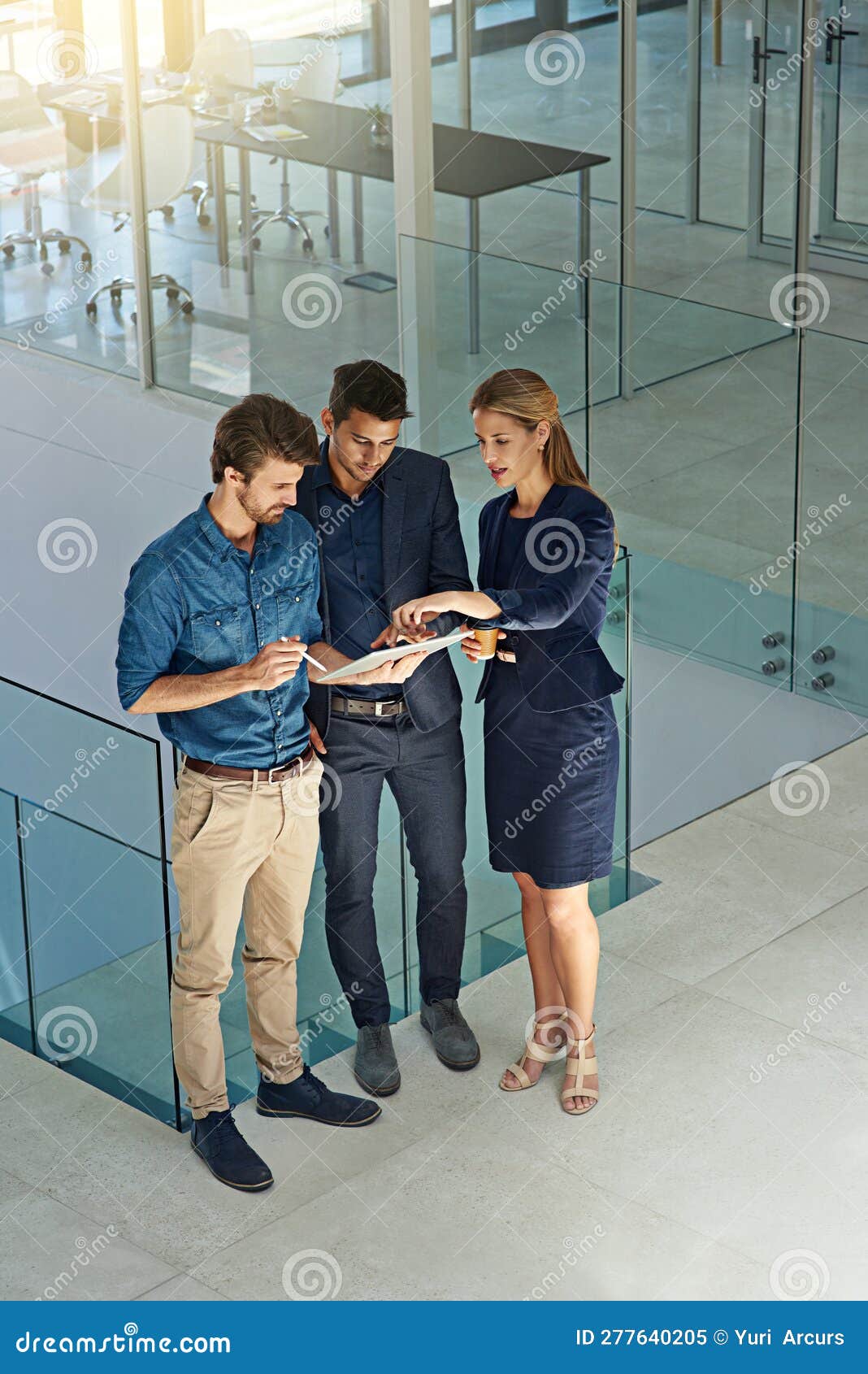 Going through the Teams Figures. Three Colleagues Talking Together Over ...