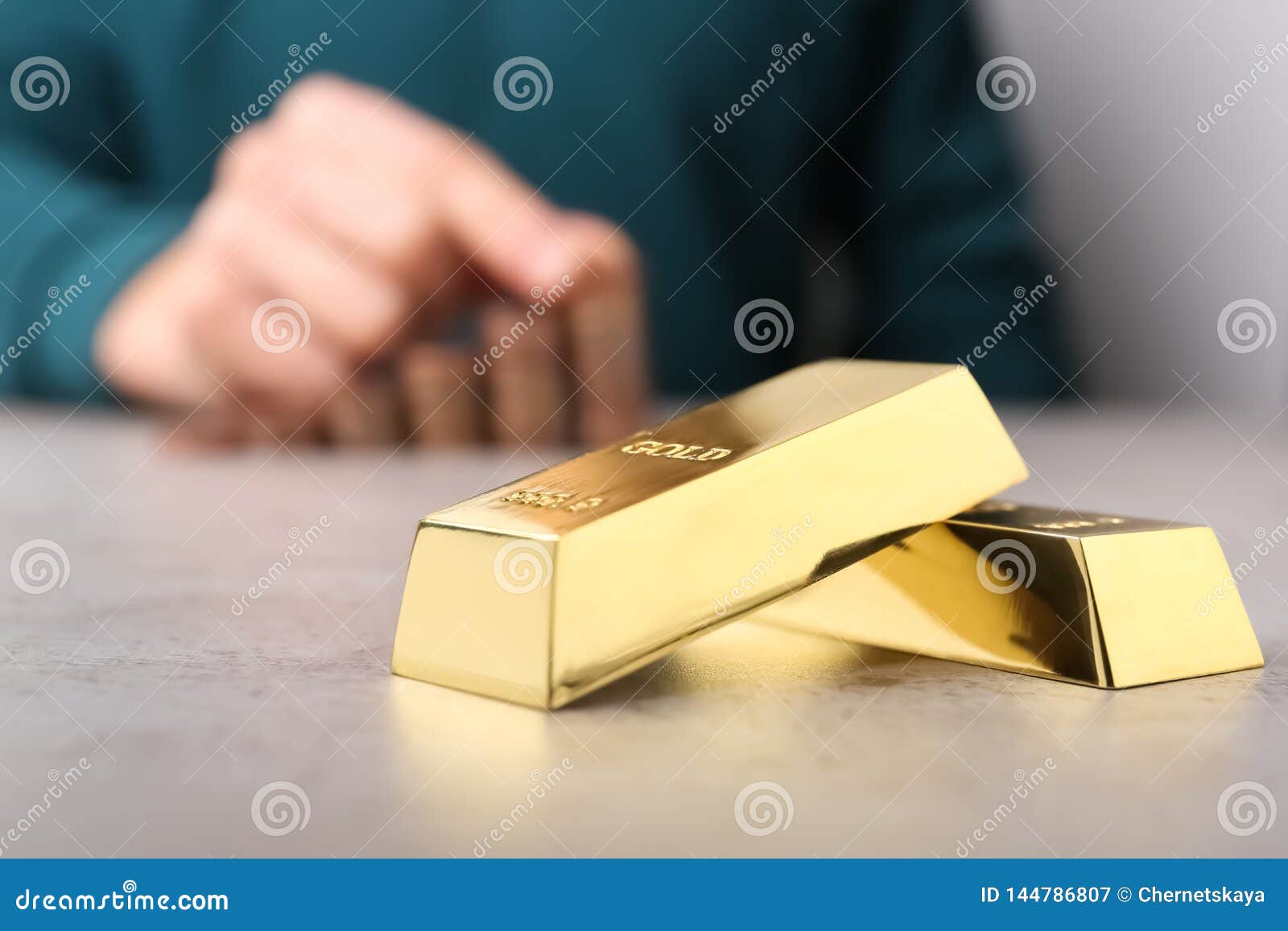 Gold Bars and Man Stacking Coins at Table, Closeup. Stock Image - Image ...