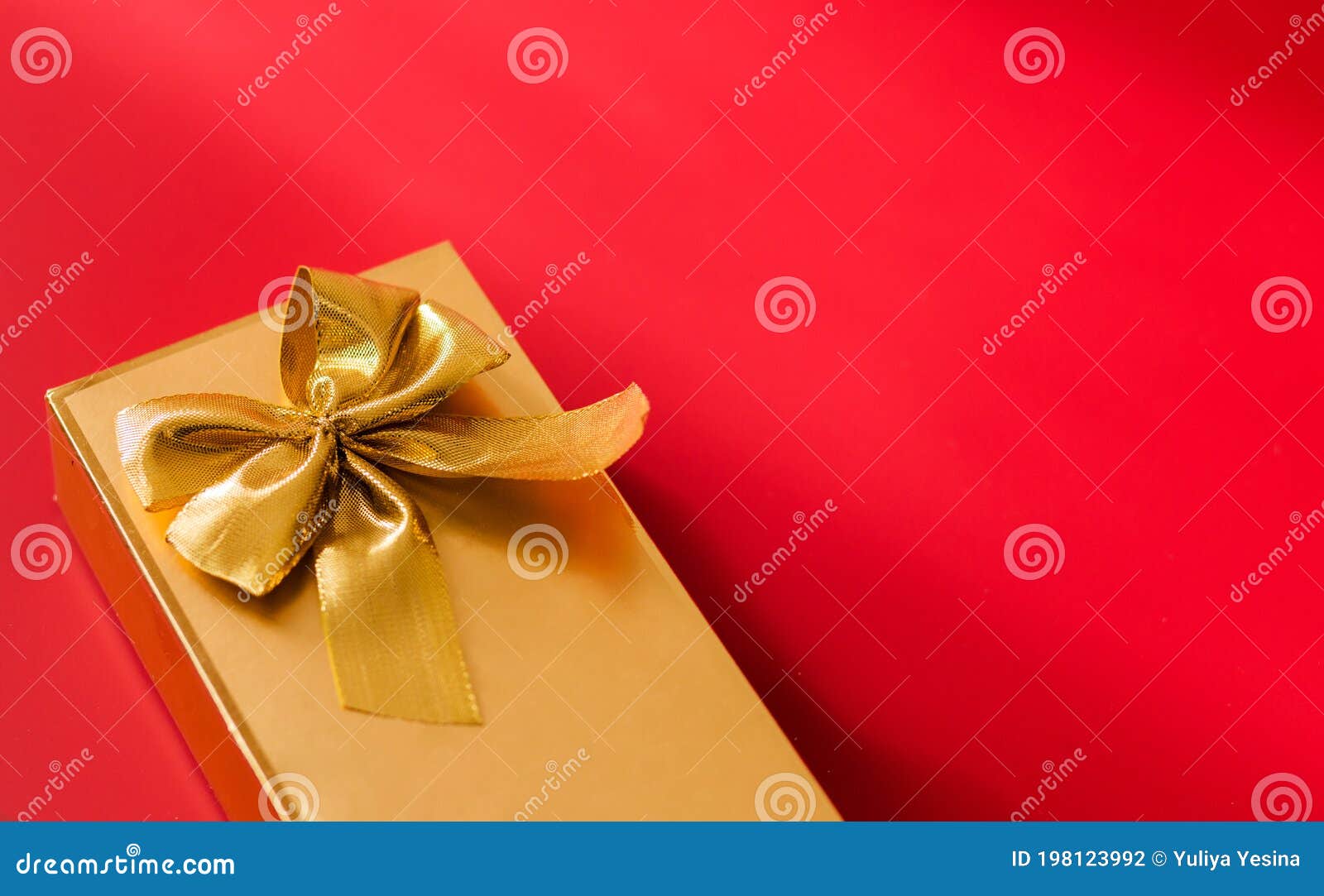 Gold Color Gift Wrap with Gold Bow on Red Background Stock Photo ...