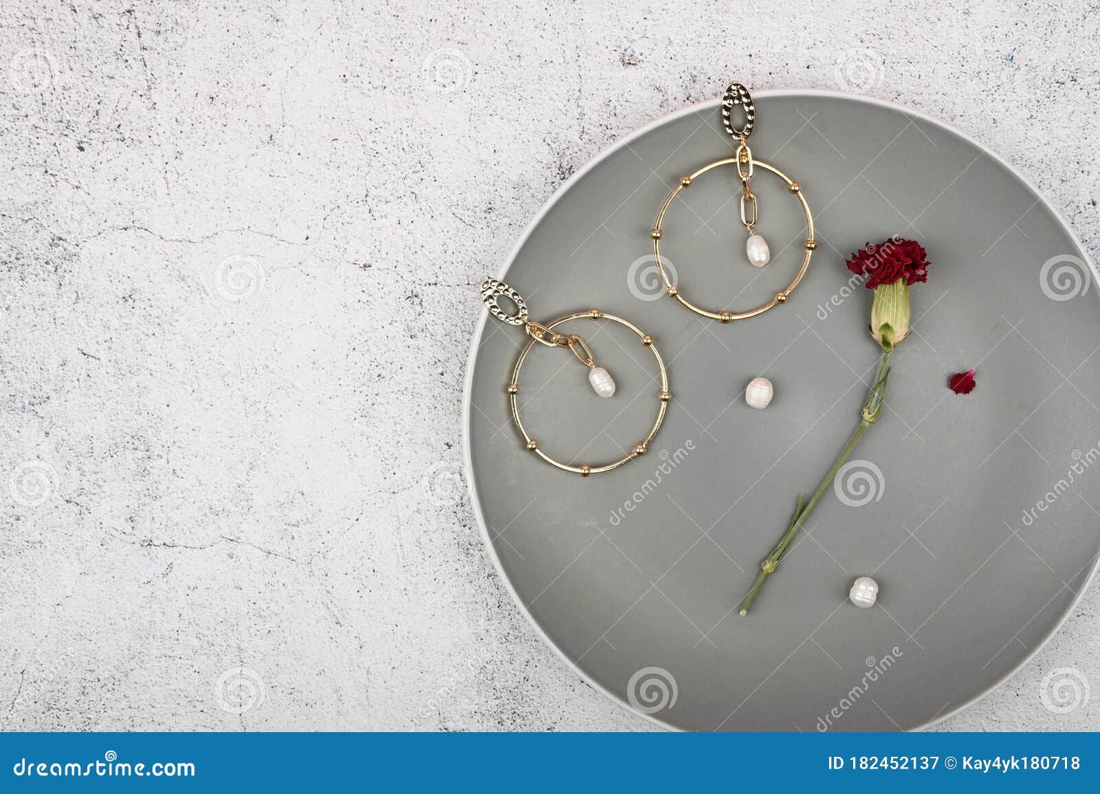 Gold earrings in a plate stock image. Image of gold - 182452137