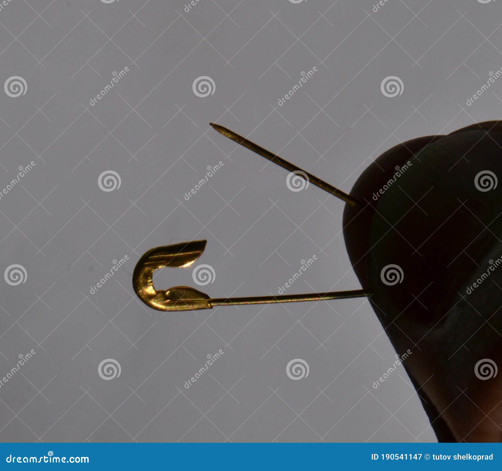 Gold Pin on a White Backdrop Stock Image - Image of hand, yellow: 190541147