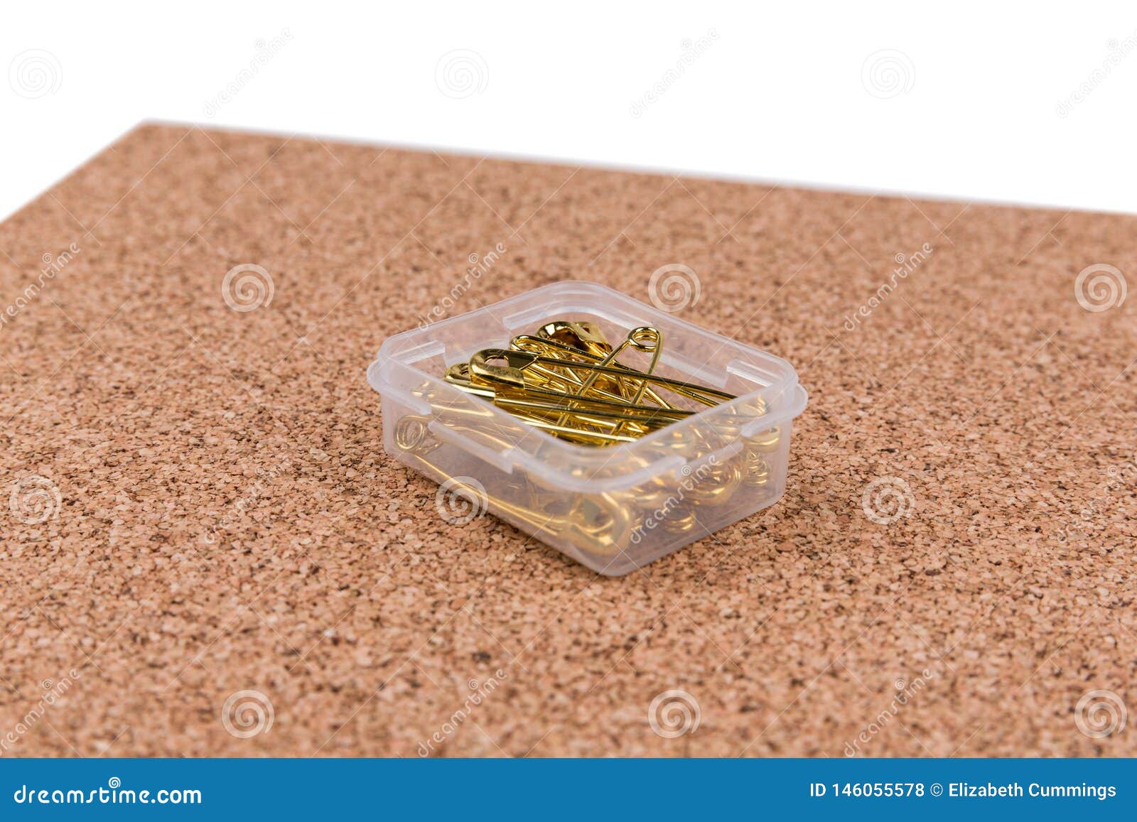 Gold Safety Pins in a Container on a Piece of Cork Stock Photo - Image ...