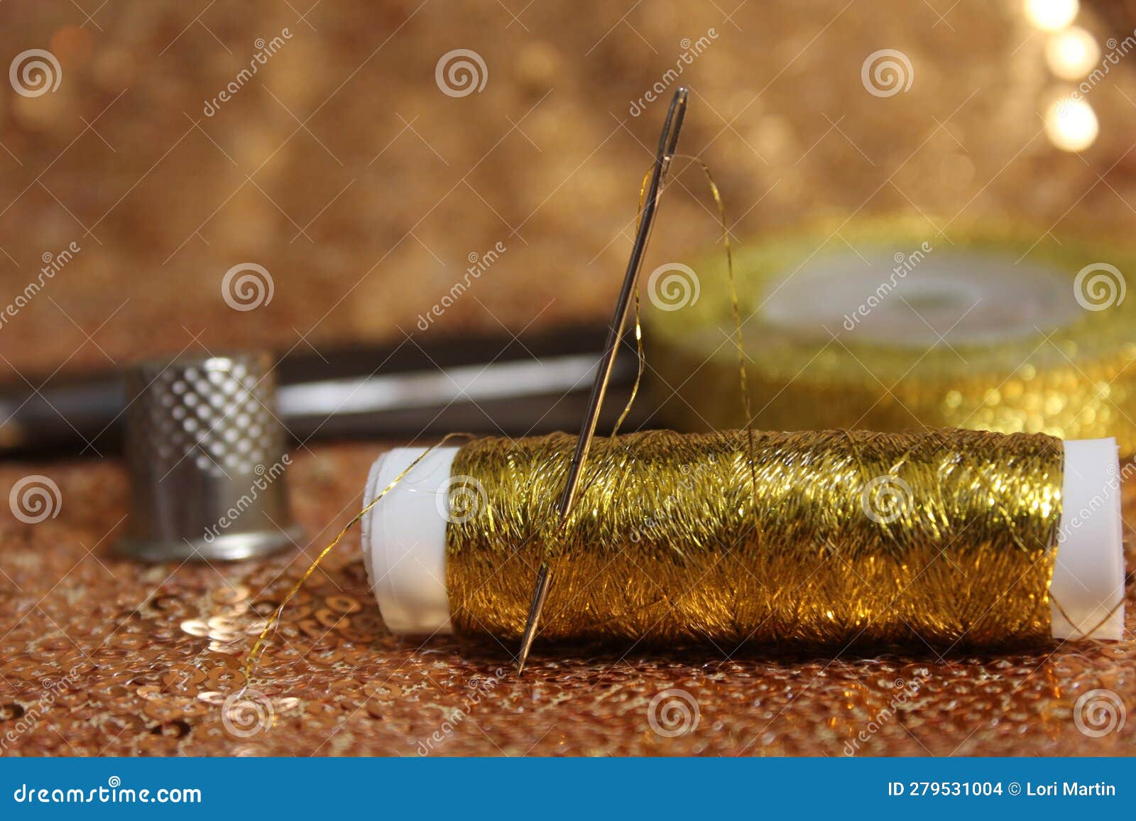 Gold Sequins on Fabric with Spool of Gold Metallic Thread and Thimble ...