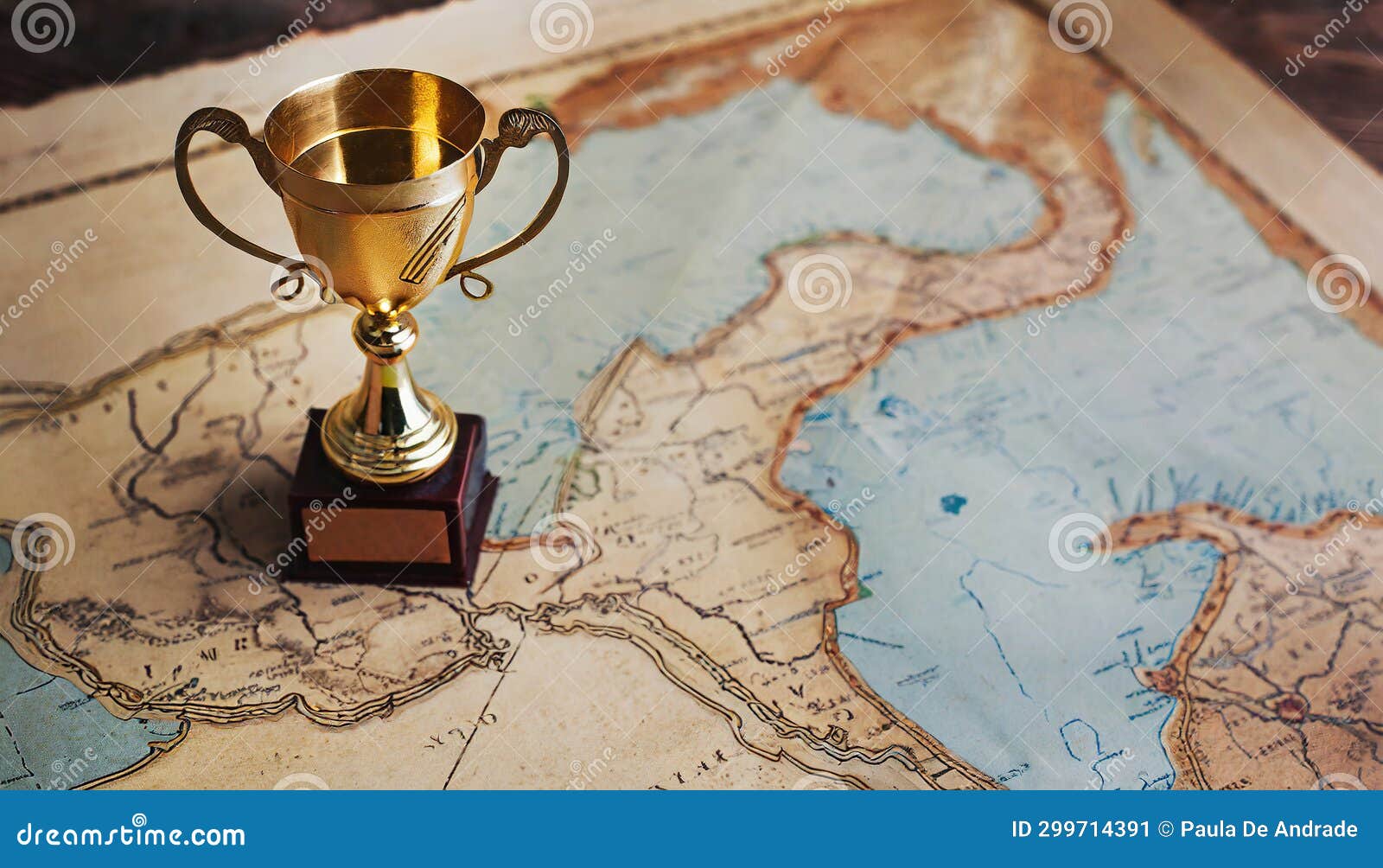 Gold Trophy Sits on Top of an Old Map with Mountains in the Background ...