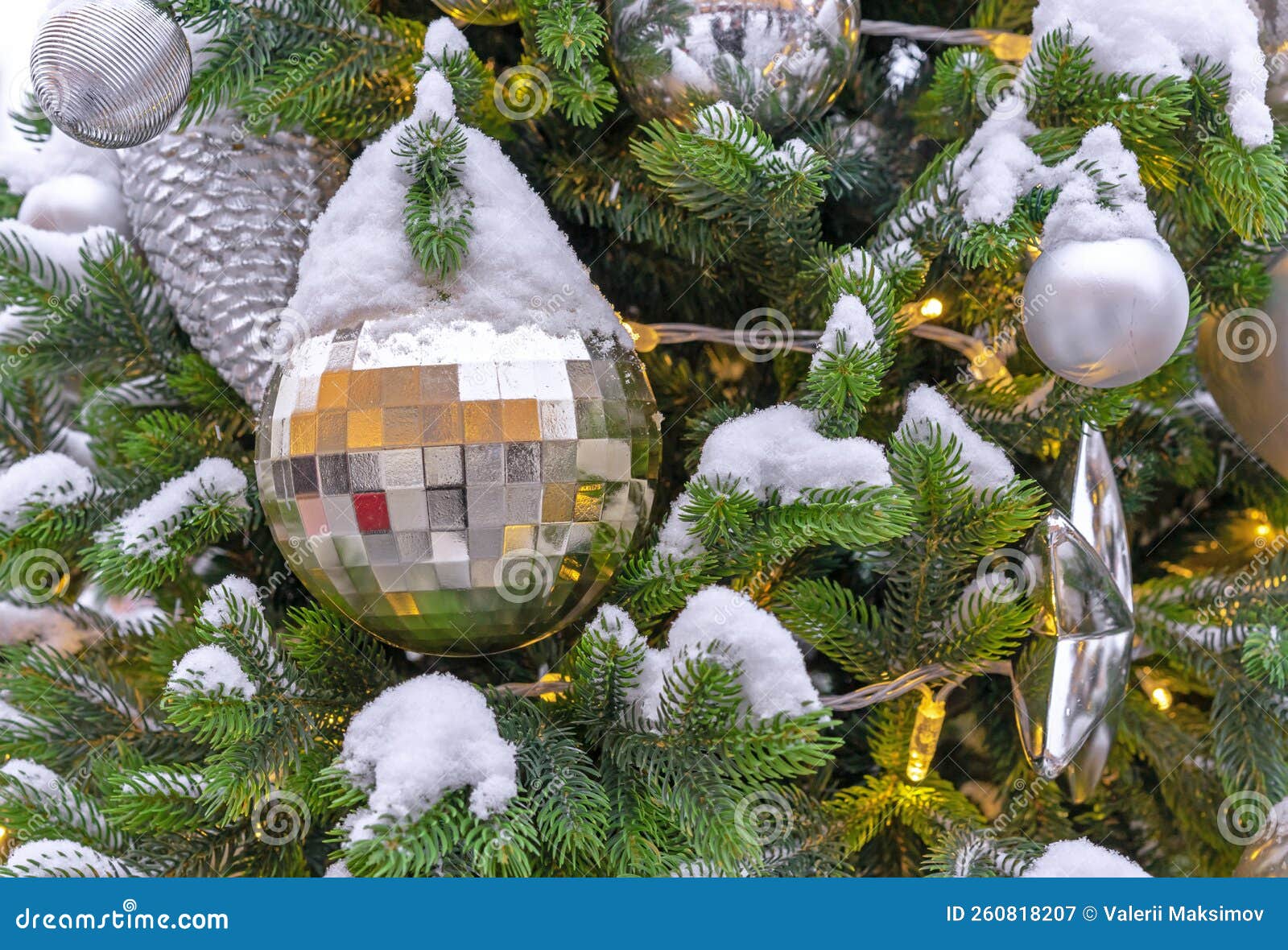 Golden Christmas Ball with Square Edges on a Snowy Christmas Tree ...
