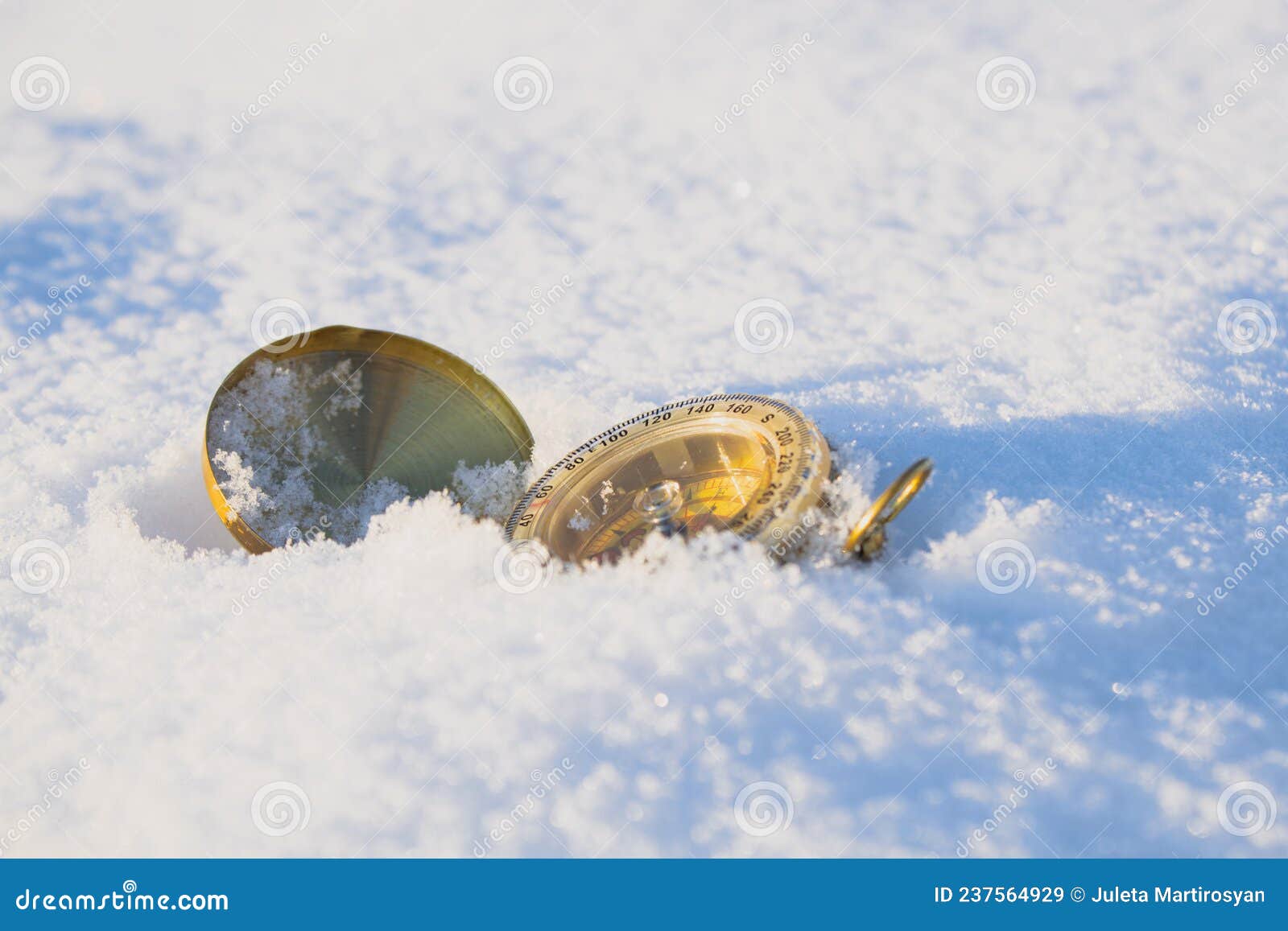 Golden compass in the snow stock image. Image of north - 237564929