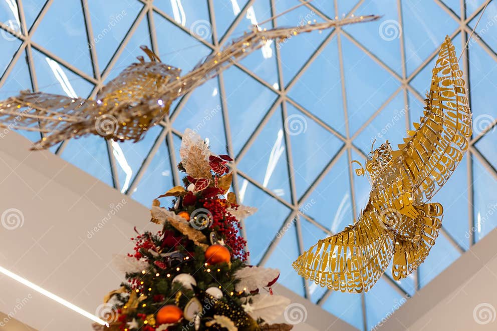 Golden Decorative Owls Hover Over a Christmas Tree Installed in a Large ... Golden Decorative Owls Hover Over a Christmas Tree Installed in a Large ...