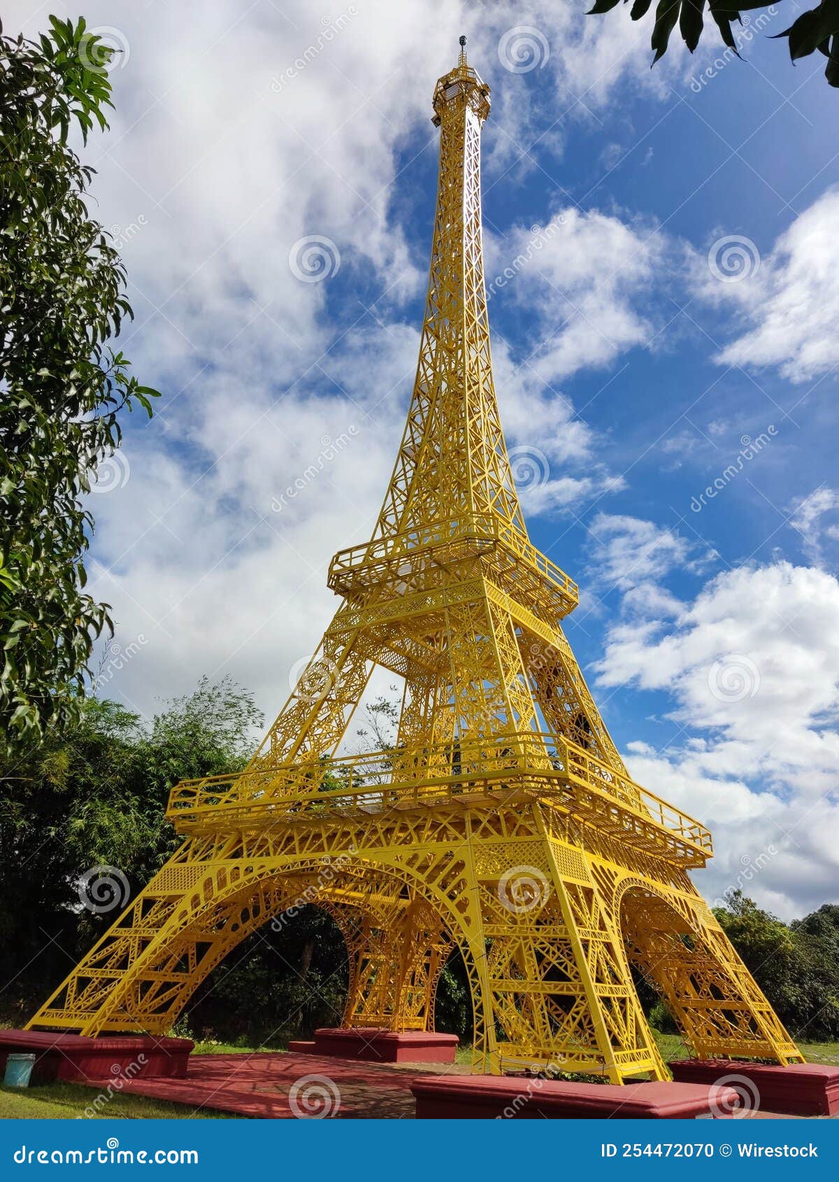 Golden Eifel Tower in the Park with a Cloudy Blue Sky Stock Photo ...